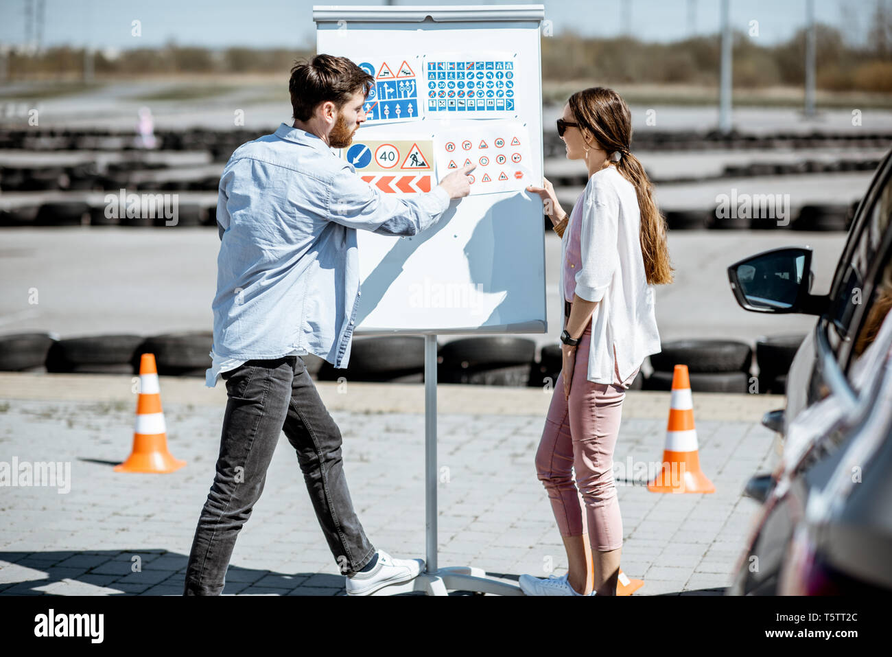 Male instructor showing traffic signs to a young female student ...