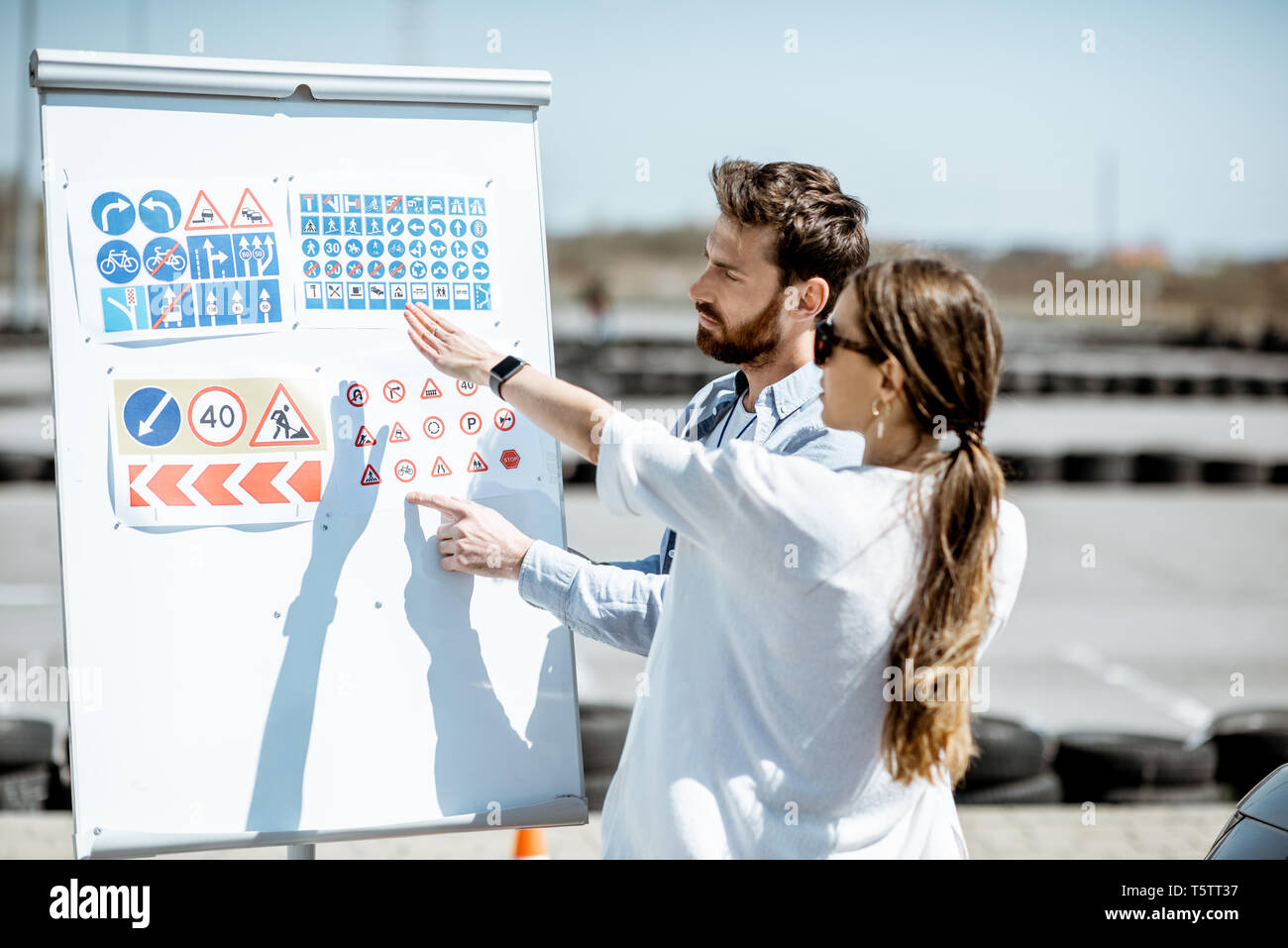 Male instructor showing traffic signs to a young female student ...