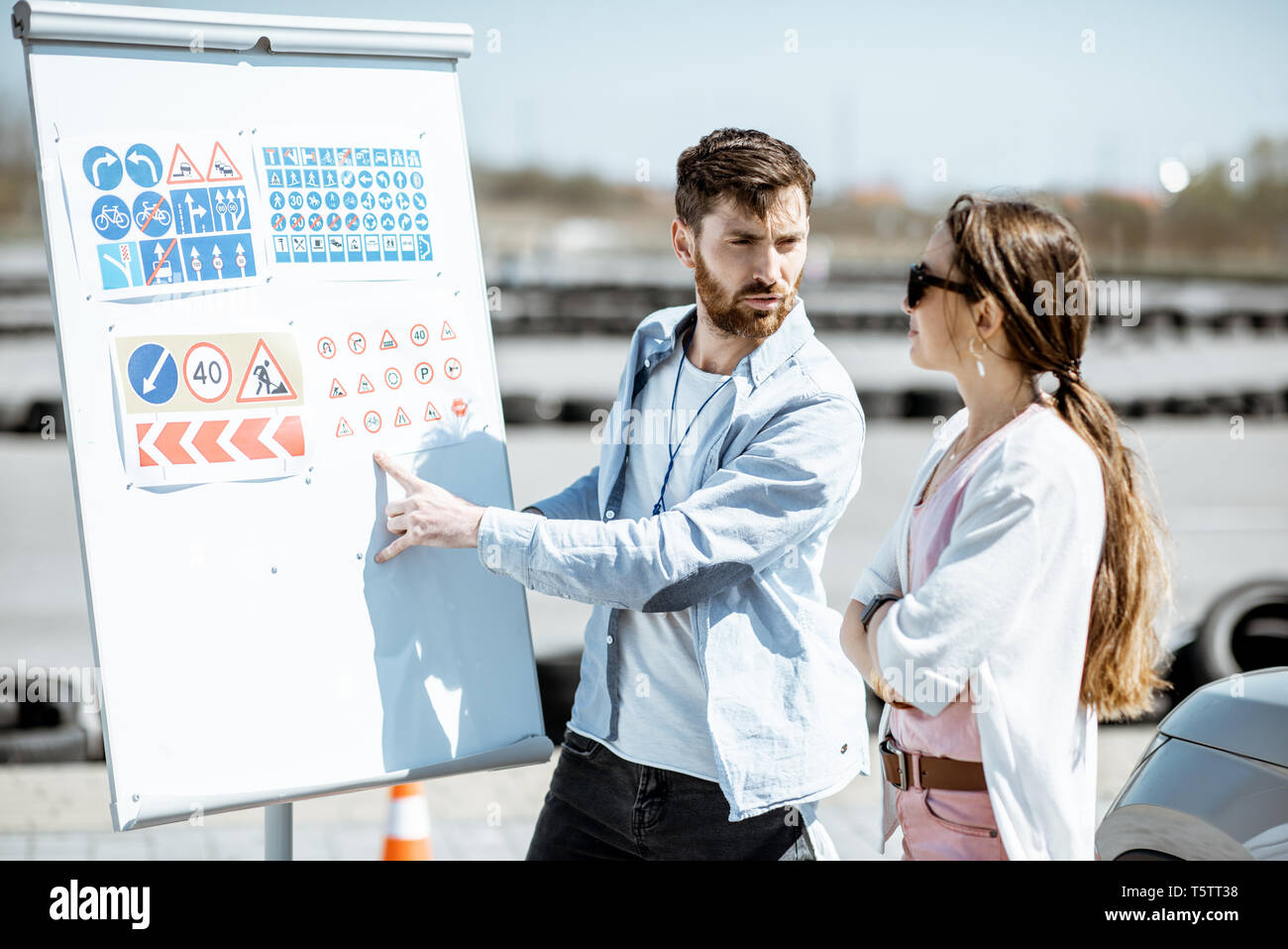 Male instructor showing traffic signs to a young female student ...