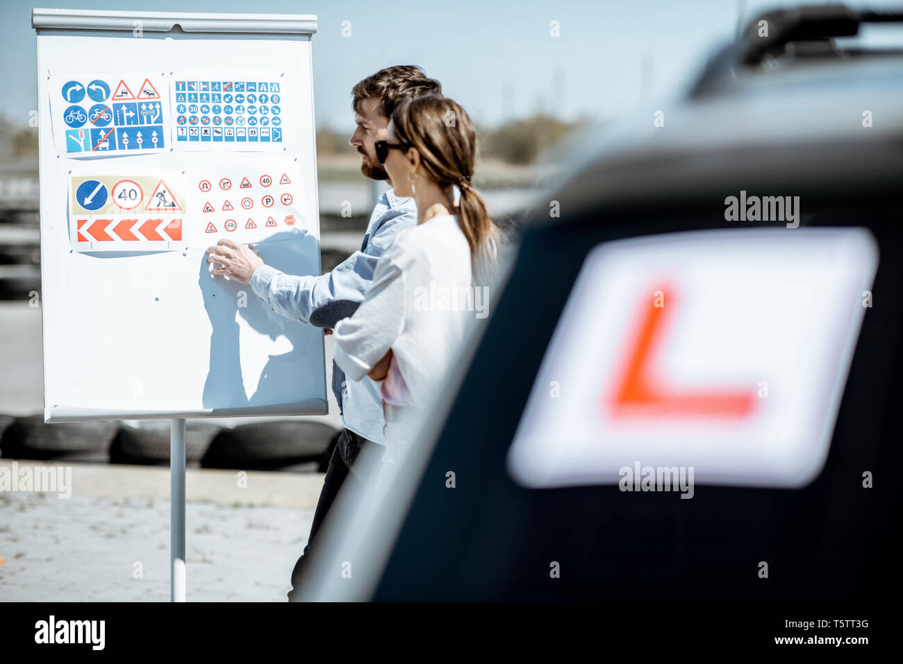 Male instructor showing traffic signs to a young female student ...