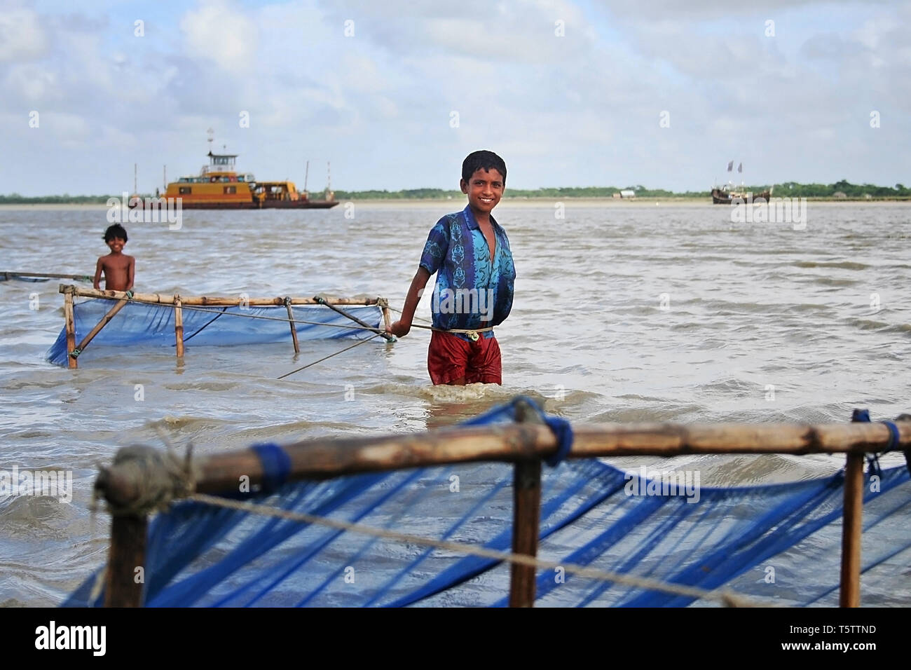 Children catching prawns on the bank of the river Andharmanik, Kalapara ...