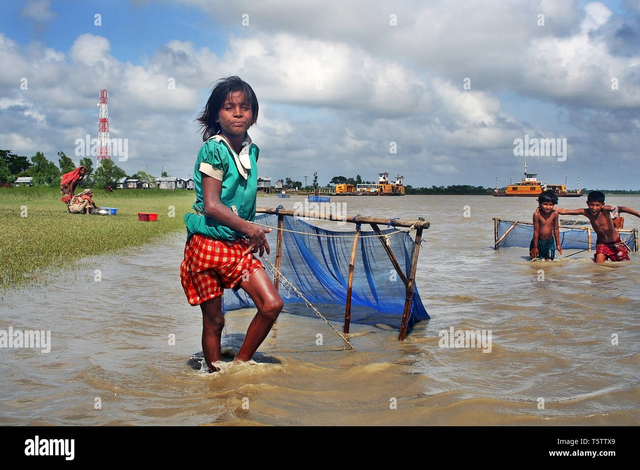 Children catching prawns on the bank of the river Andharmanik, Kalapara ...