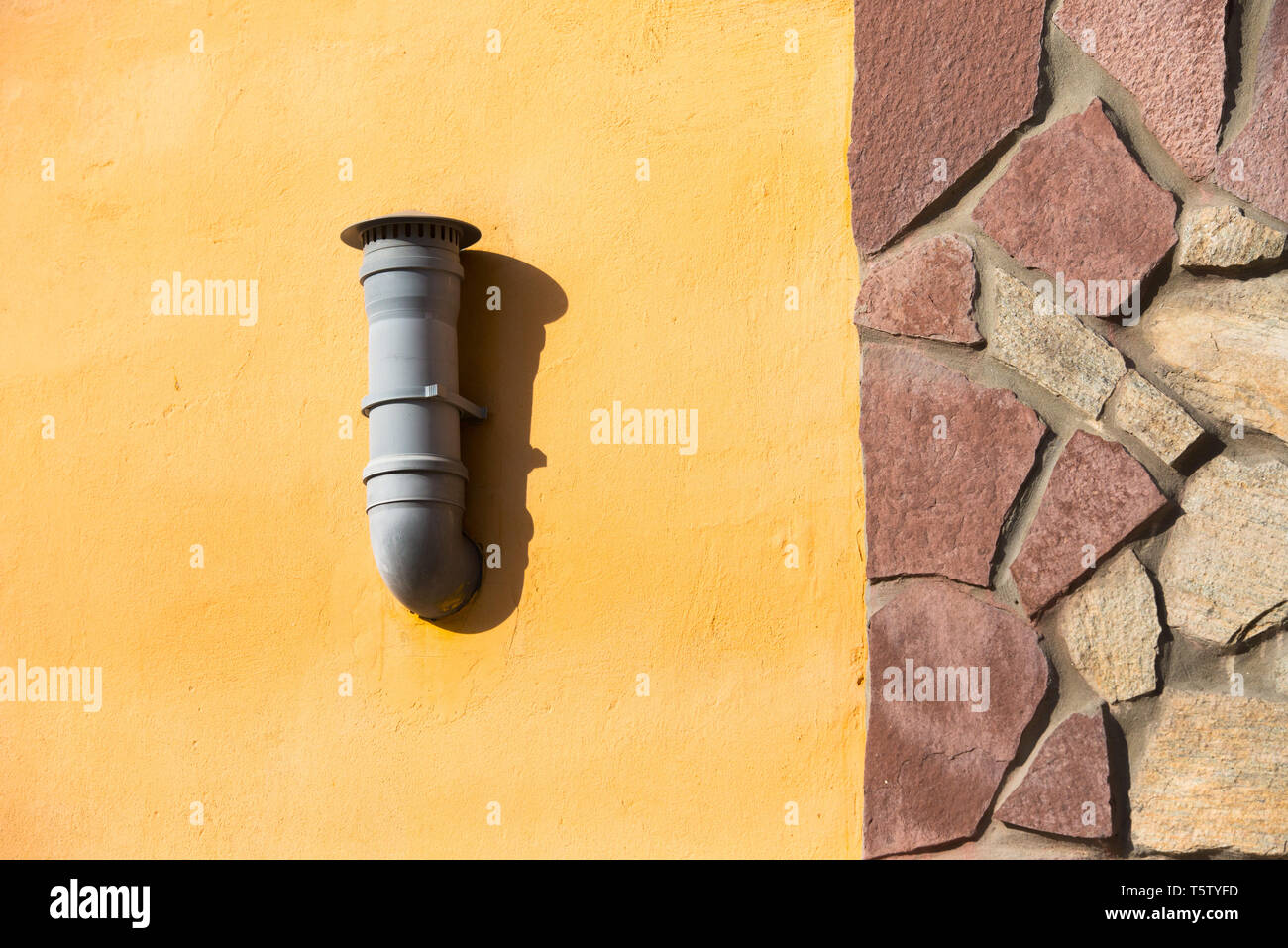 Plastic vent pipe on the orange wall. Air ventilation pipe mounted on ...
