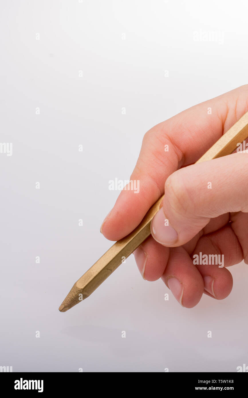 Hand holding a gold color pencil on a white background Stock Photo - Alamy