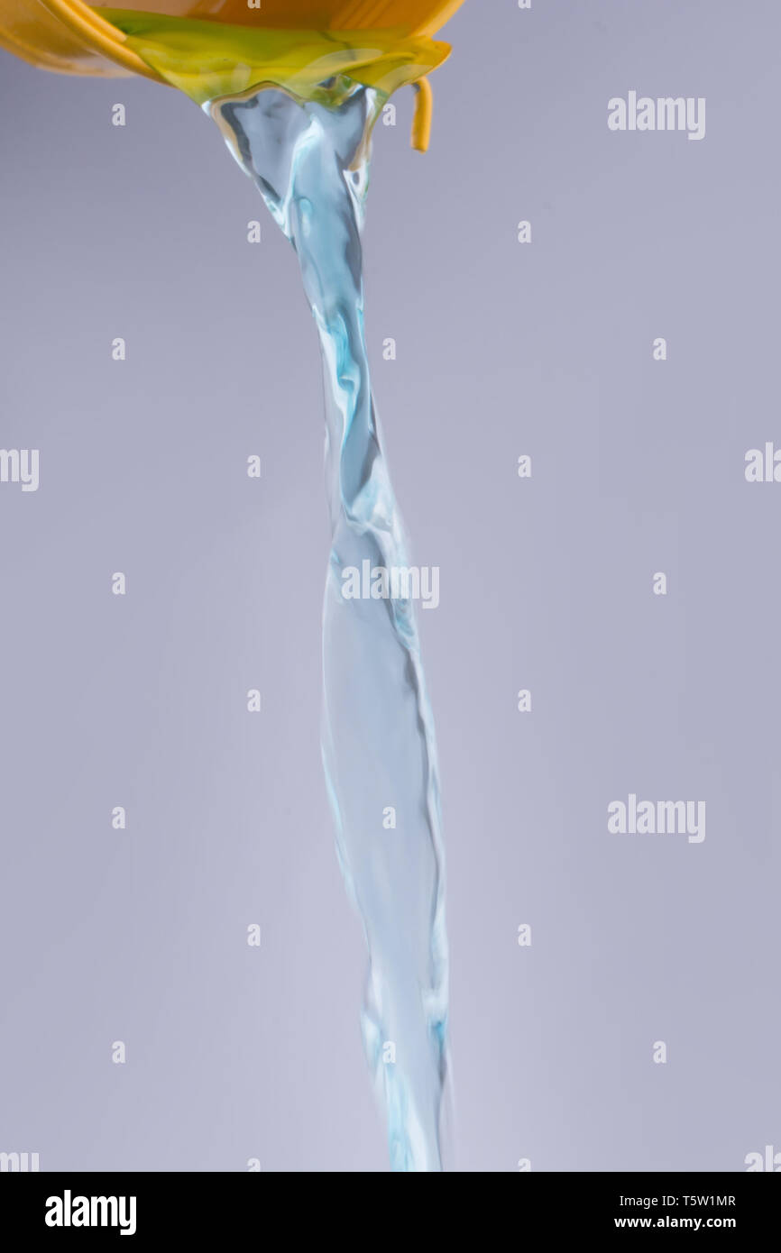 Water flowing out of little yellow bucket Stock Photo - Alamy