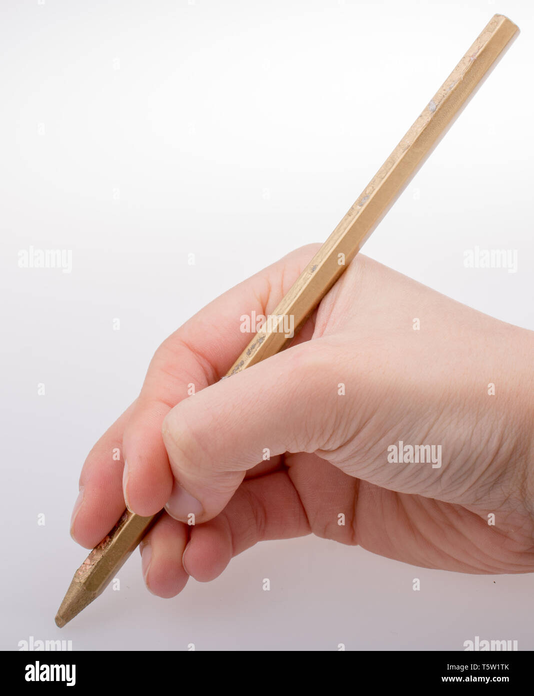 Hand holding a gold color pencil on a white background Stock Photo - Alamy