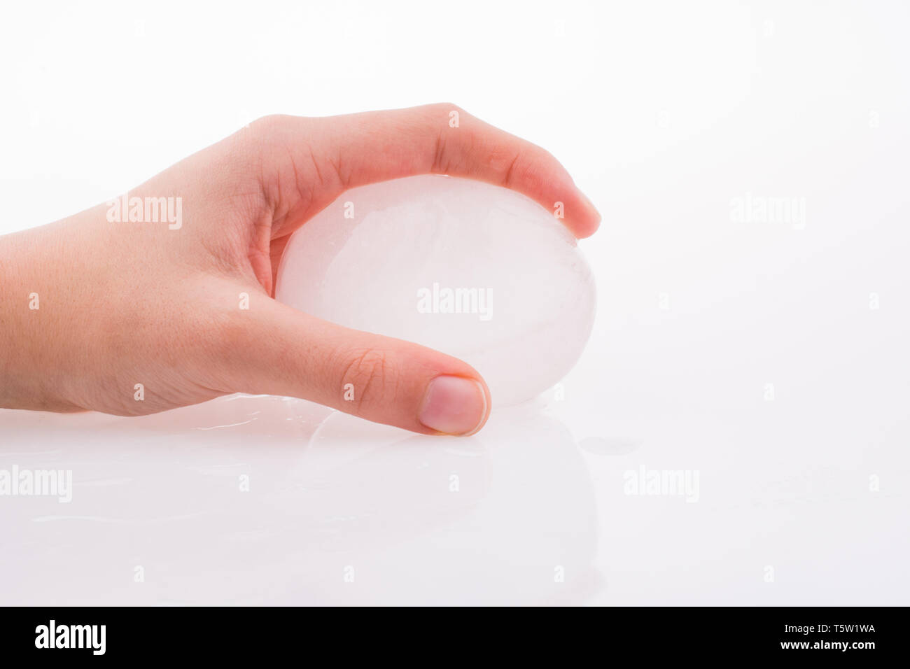 Hand holding an ice ball on a white background Stock Photo - Alamy