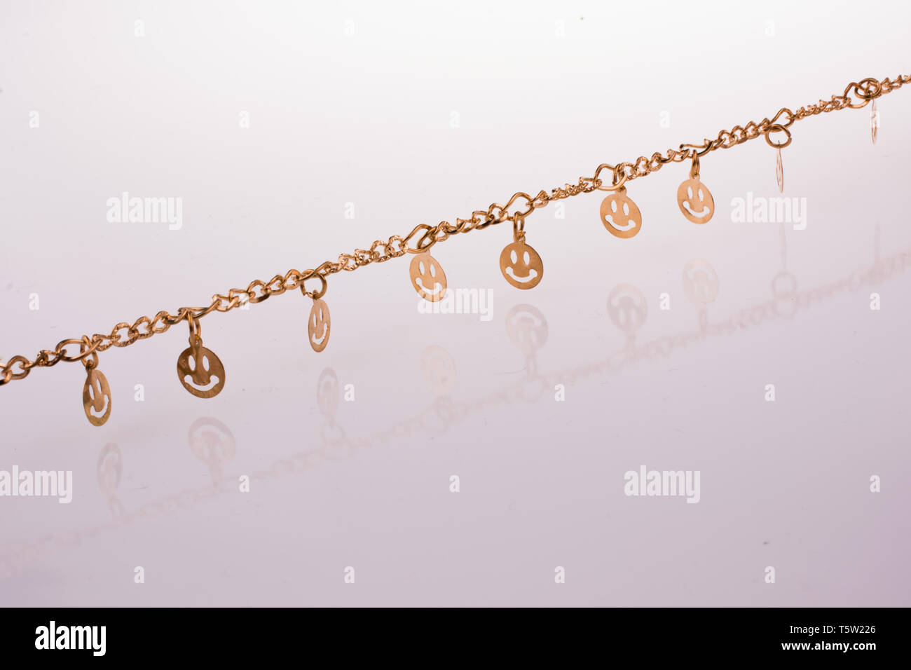 Golden color smileys arrayed on a chain in hand Stock Photo - Alamy