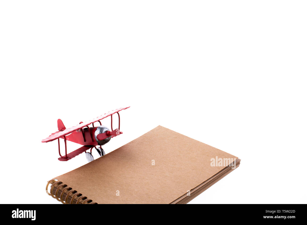 Airplane and notebook on white background Stock Photo - Alamy