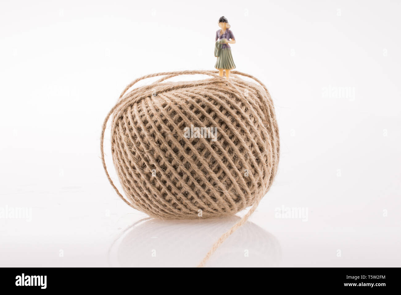 Woman figure at the top a linen spool of thread on a white background ...