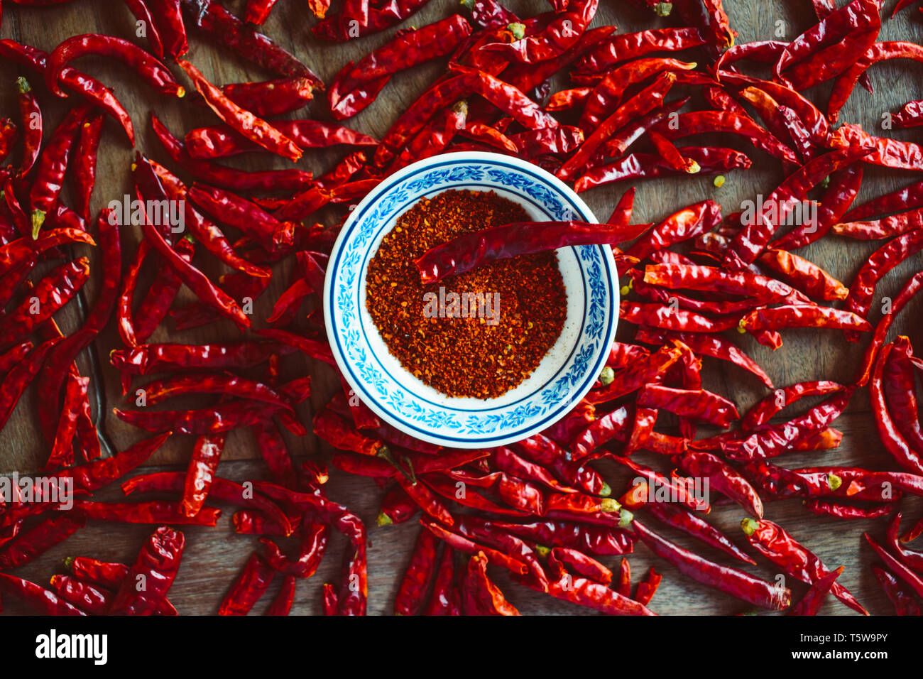 red chili pepper powder and dried peppers on a wooden table Stock Photo ...