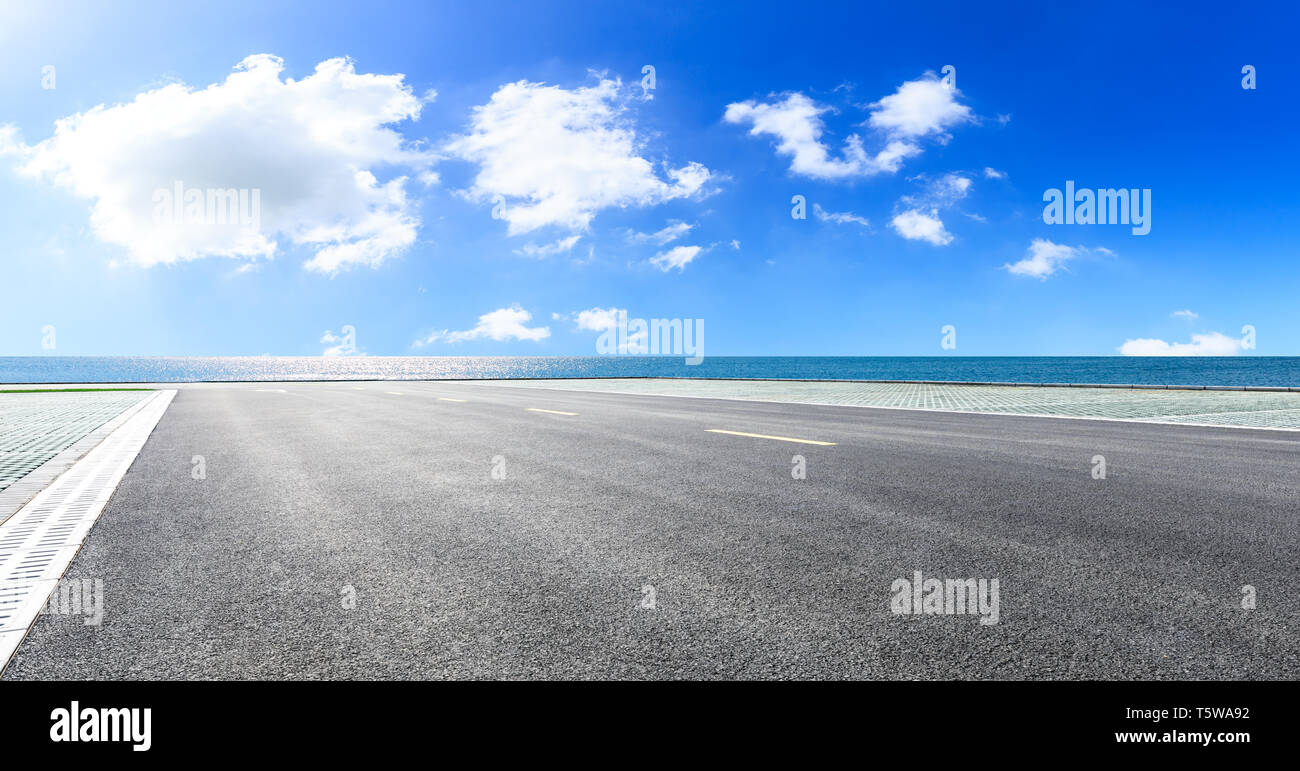 Empty asphalt road and blue sea with sky background Stock Photo - Alamy