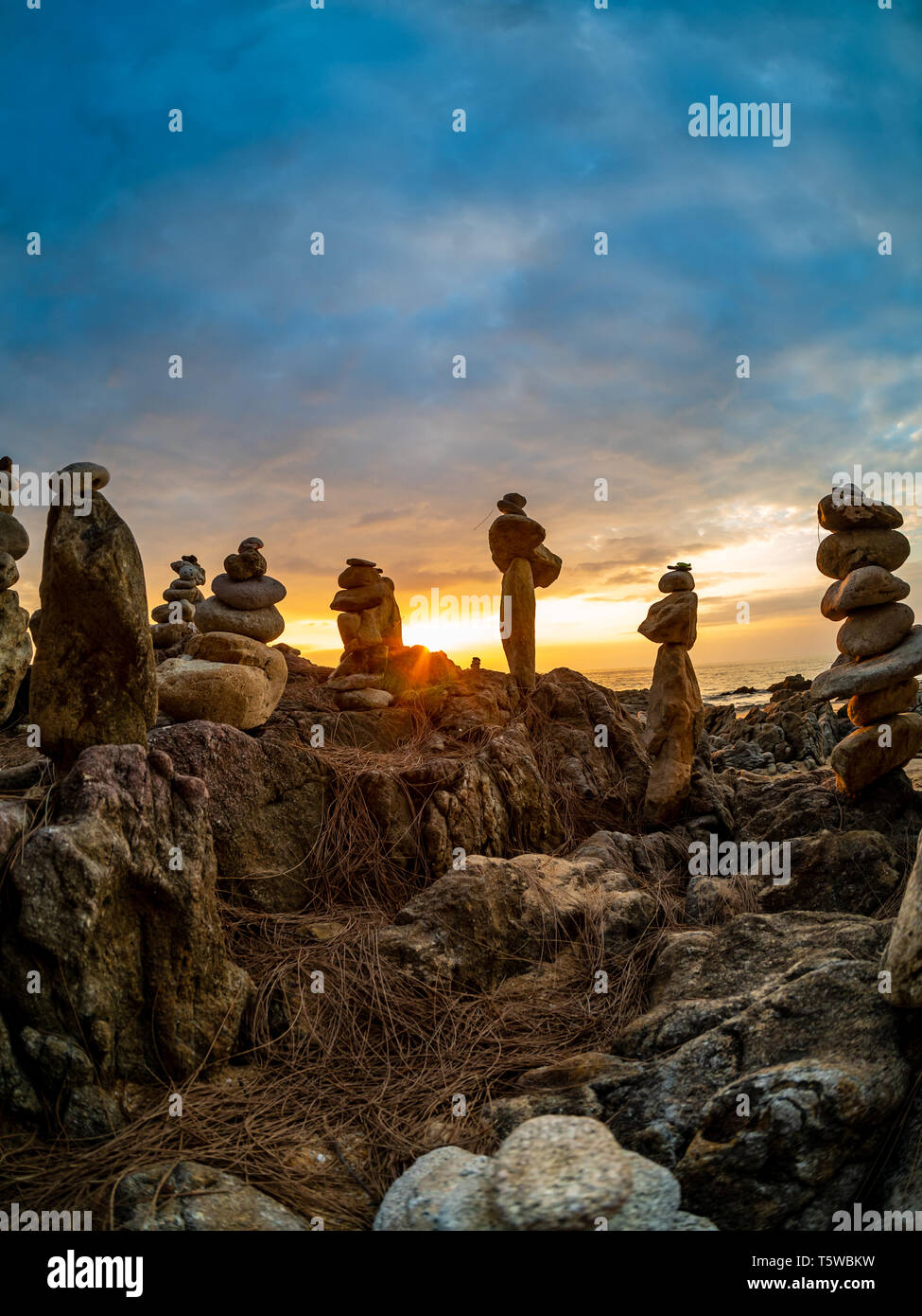 Zen stacked stones at the beach at sunset Stock Photo - Alamy