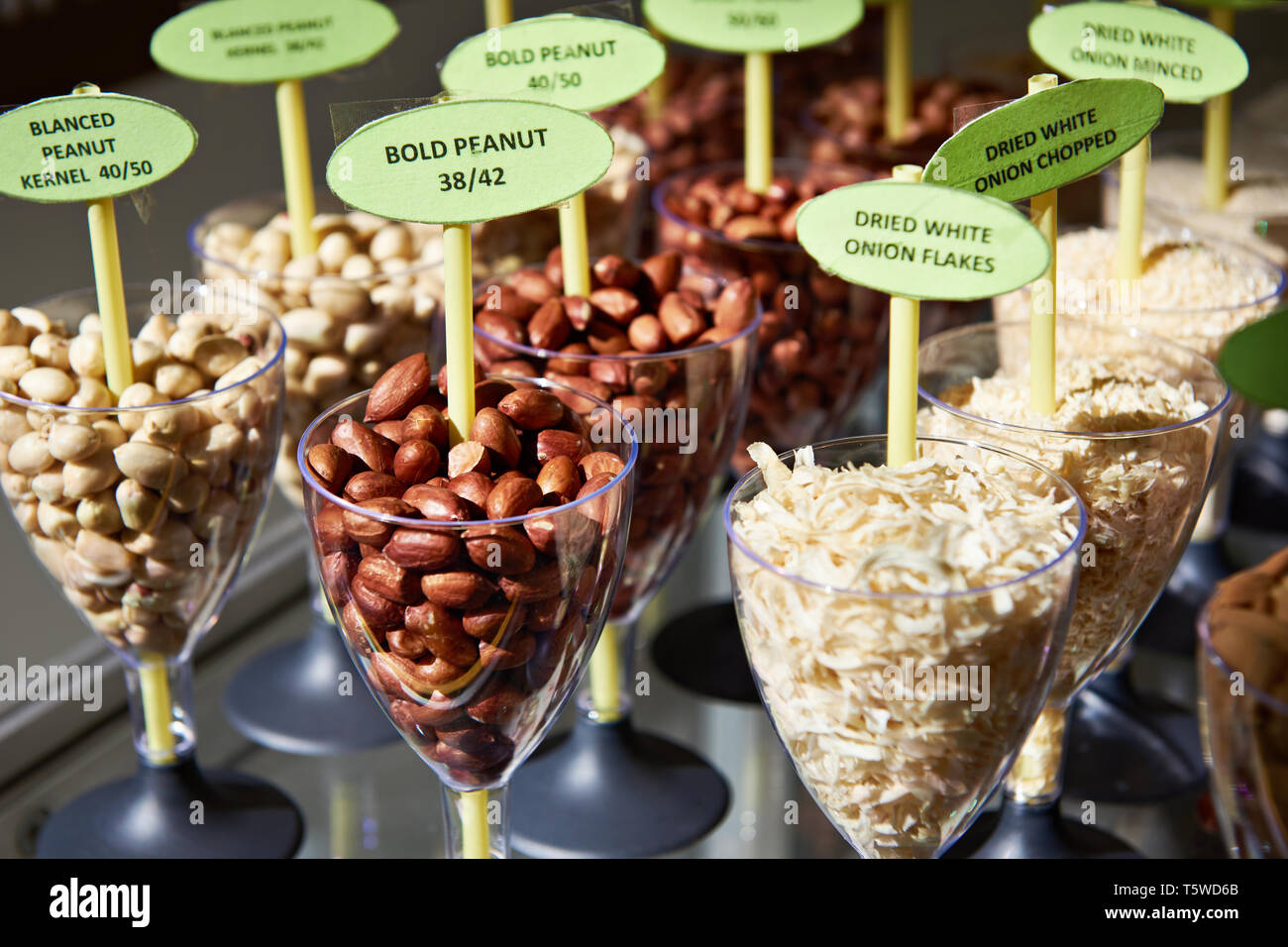 Different peanuts nuts and dried onion flakes in glass goblets Stock ...