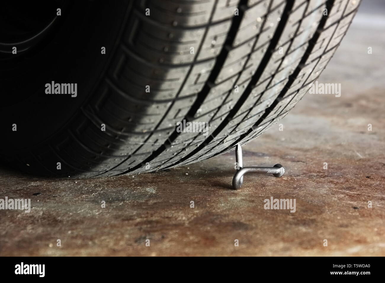 twist nail under car wheel Stock Photo - Alamy