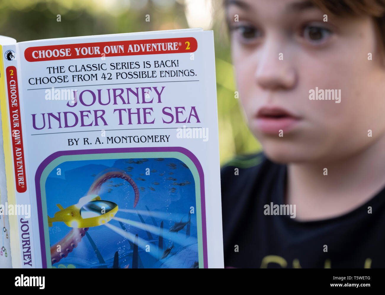 Choose Your Own Adventure Book with boy reading and reacting Stock ...