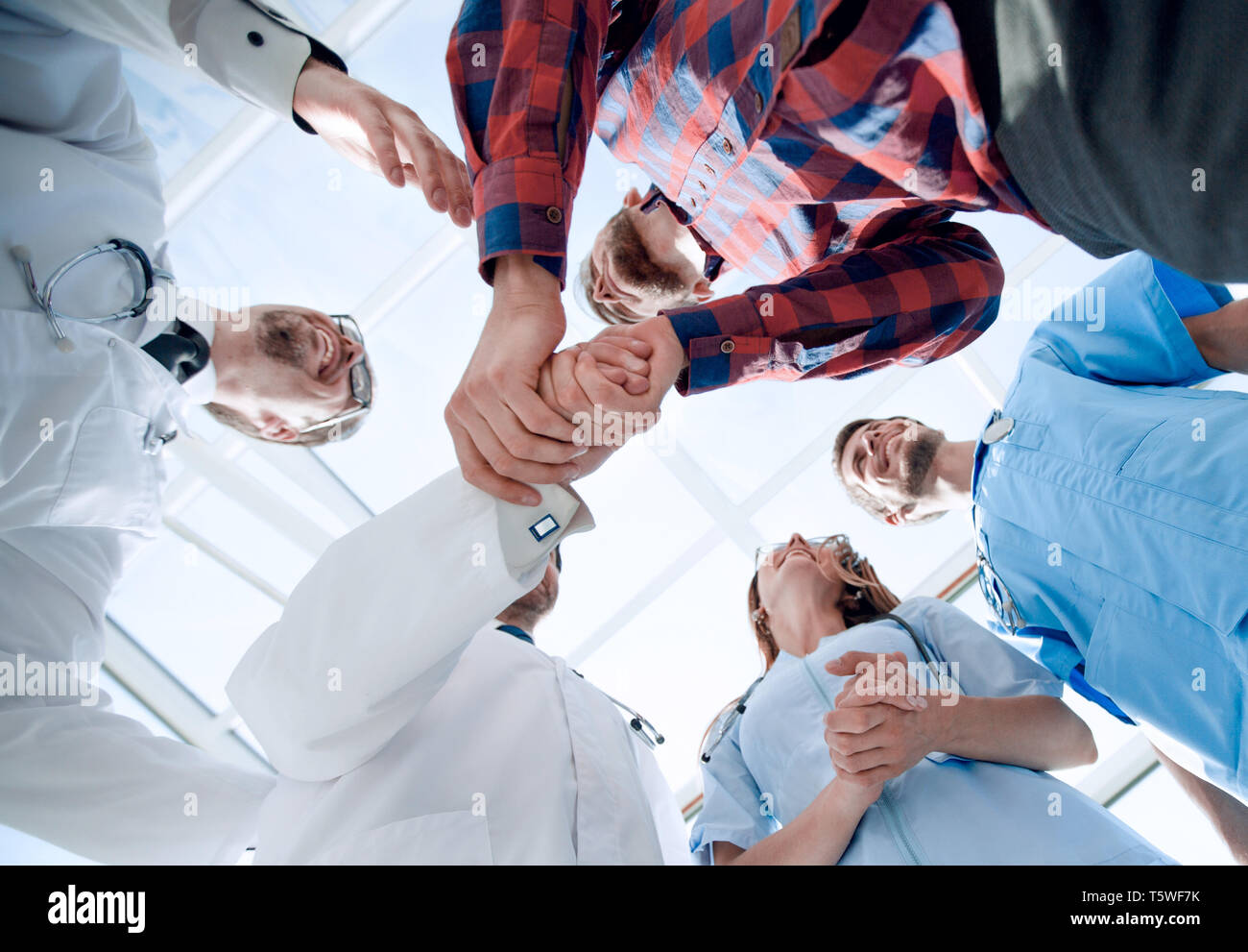 view from the bottom of a large medical team standing in a circle ...
