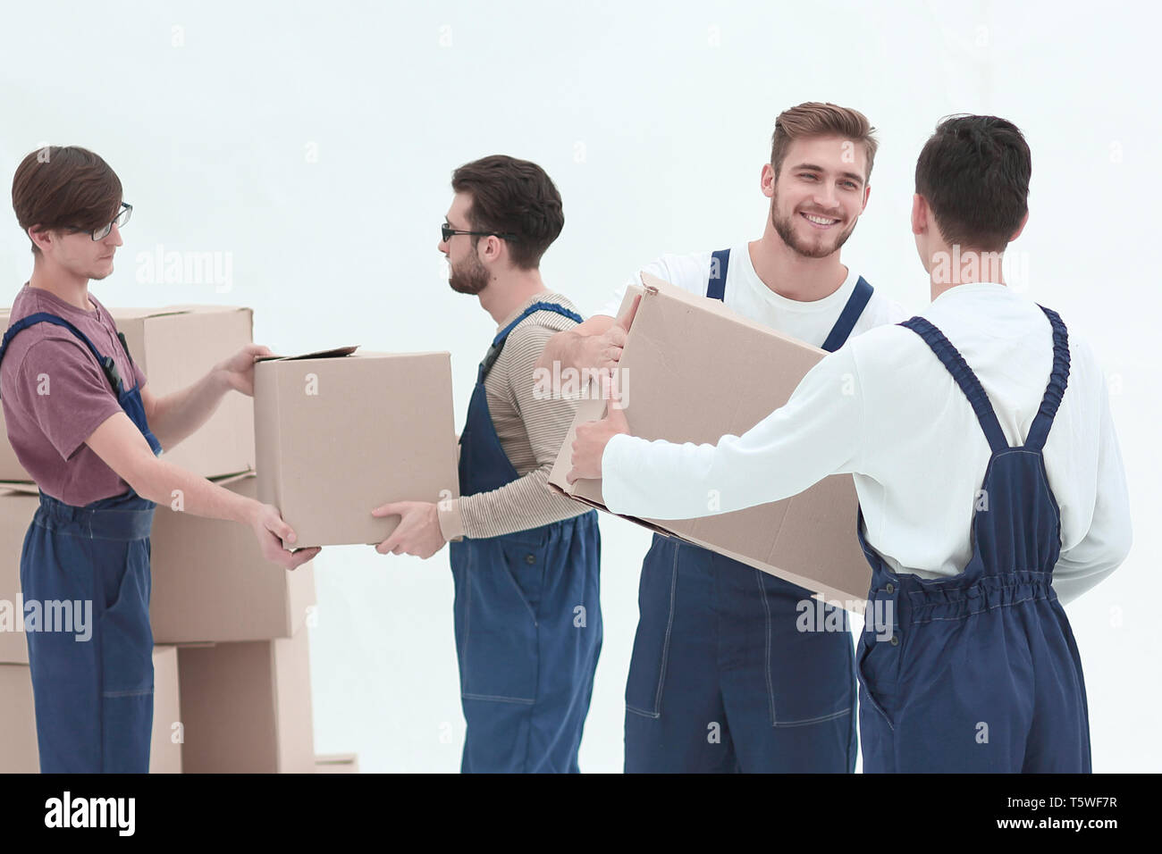 Movers lifting stack of cardboard moving boxes isolated on white Stock ...
