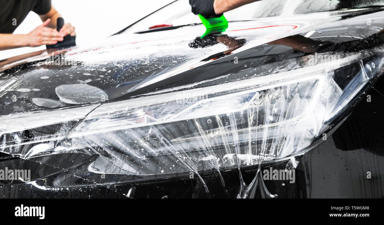 Car wrapping specialist putting vinyl foil or film on car. Protective ...