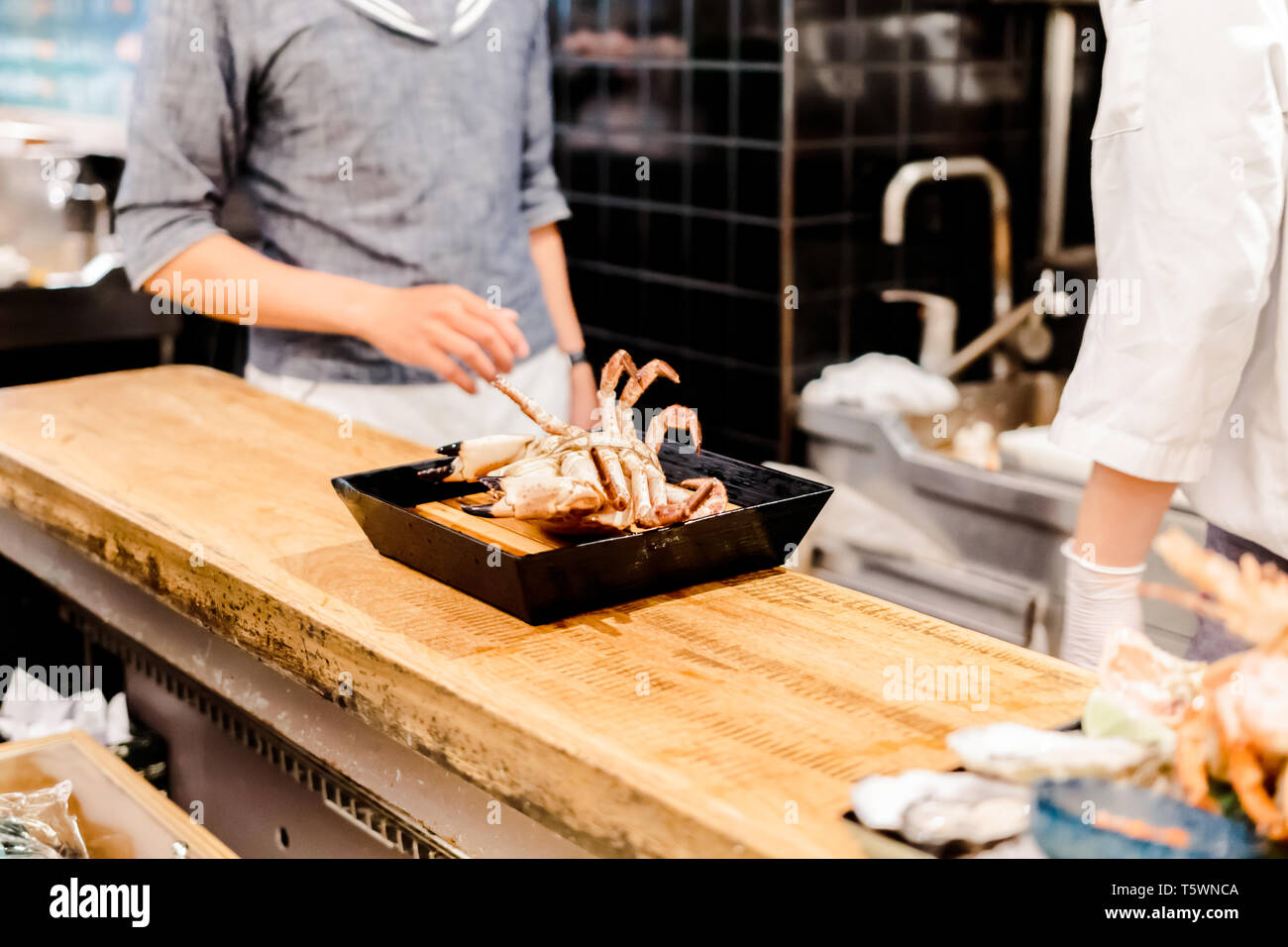 Chef at Taipei Fish Market preparing a live crab to be cooked and serve ...