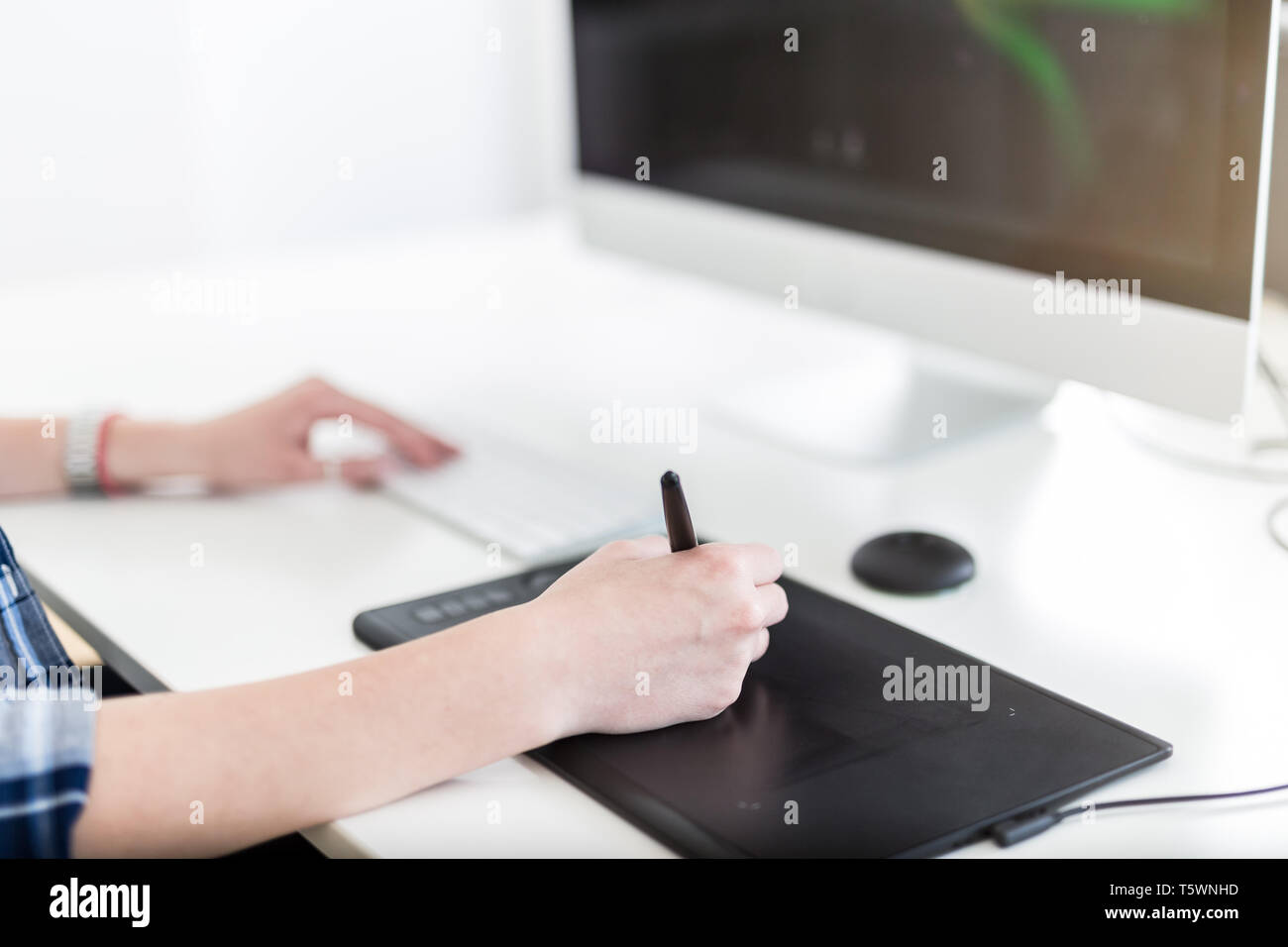 Close up of graphic designer hands using graphic tablet and keyboard in ...