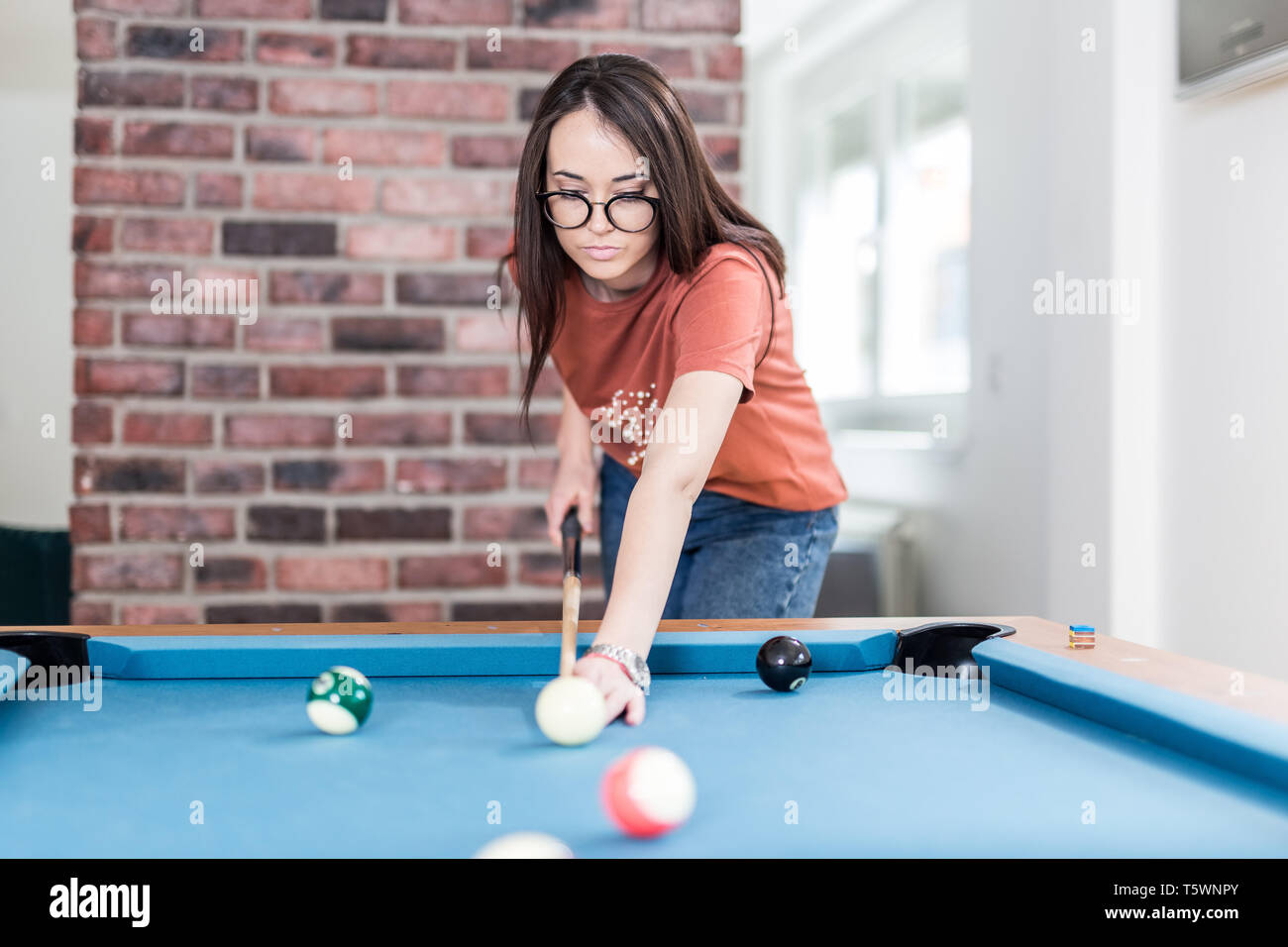 Fashionable urban woman playing pool table billiards game Stock Photo ...