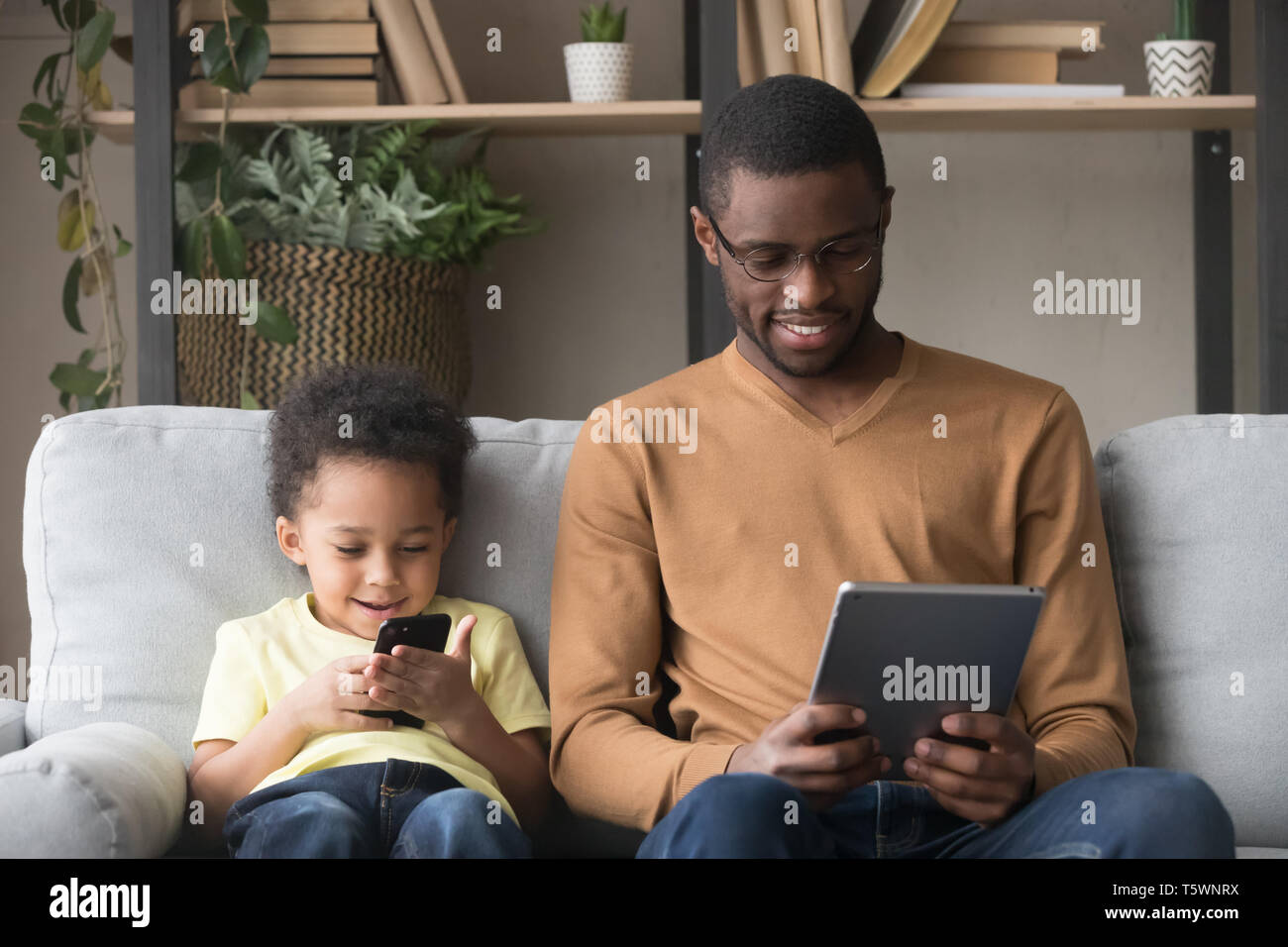Family using electronic gadgets hi-res stock photography and images - Alamy