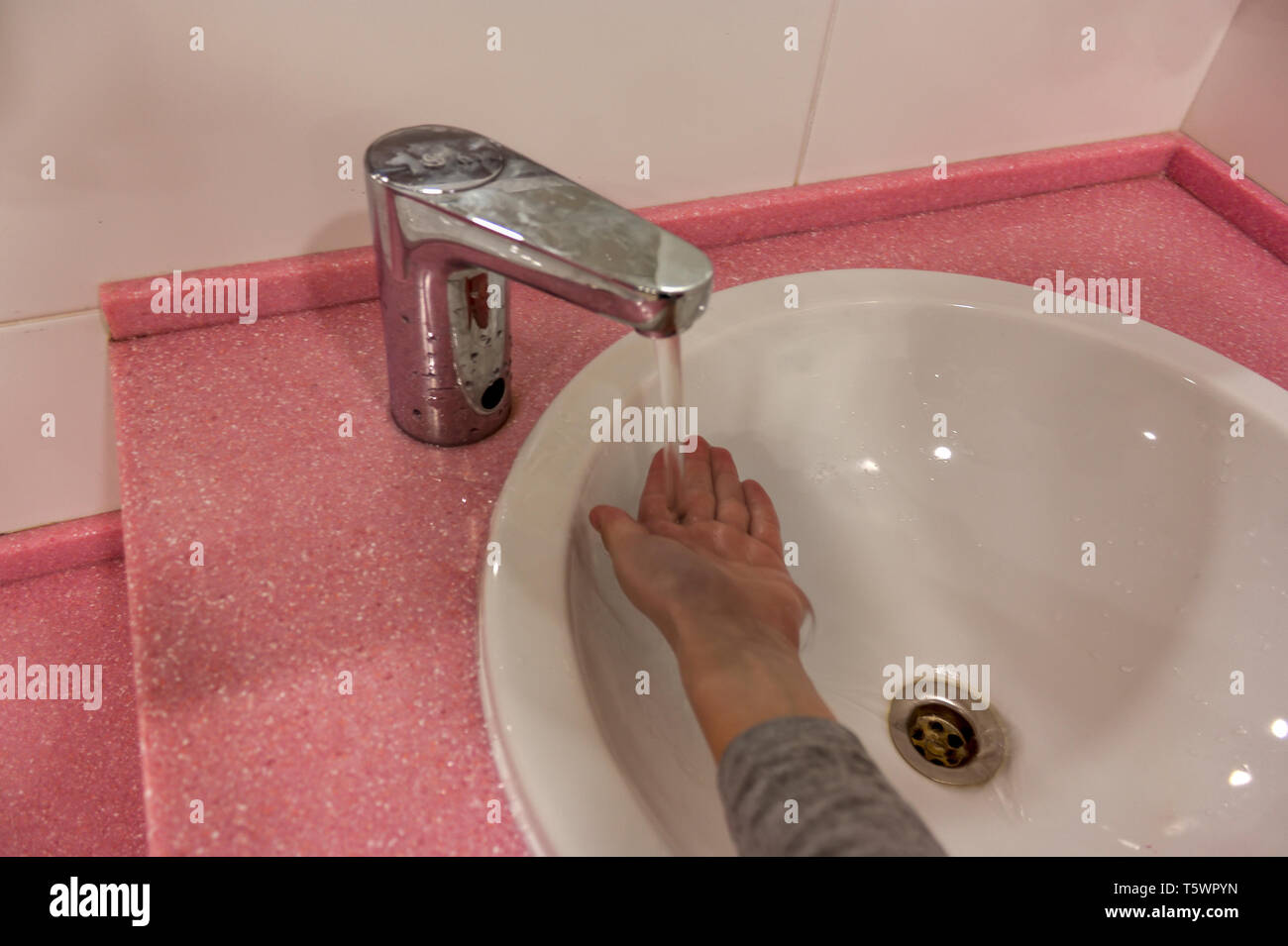 Children's hand under the tap from the mixer in the bathroom close-up ...