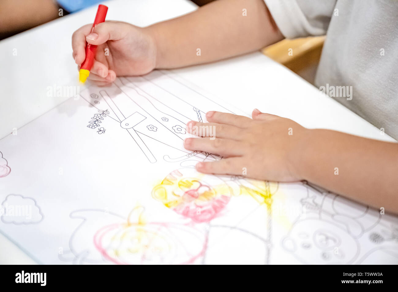 little girl plays and learns to coloring Crayon on the paper in the ice ...