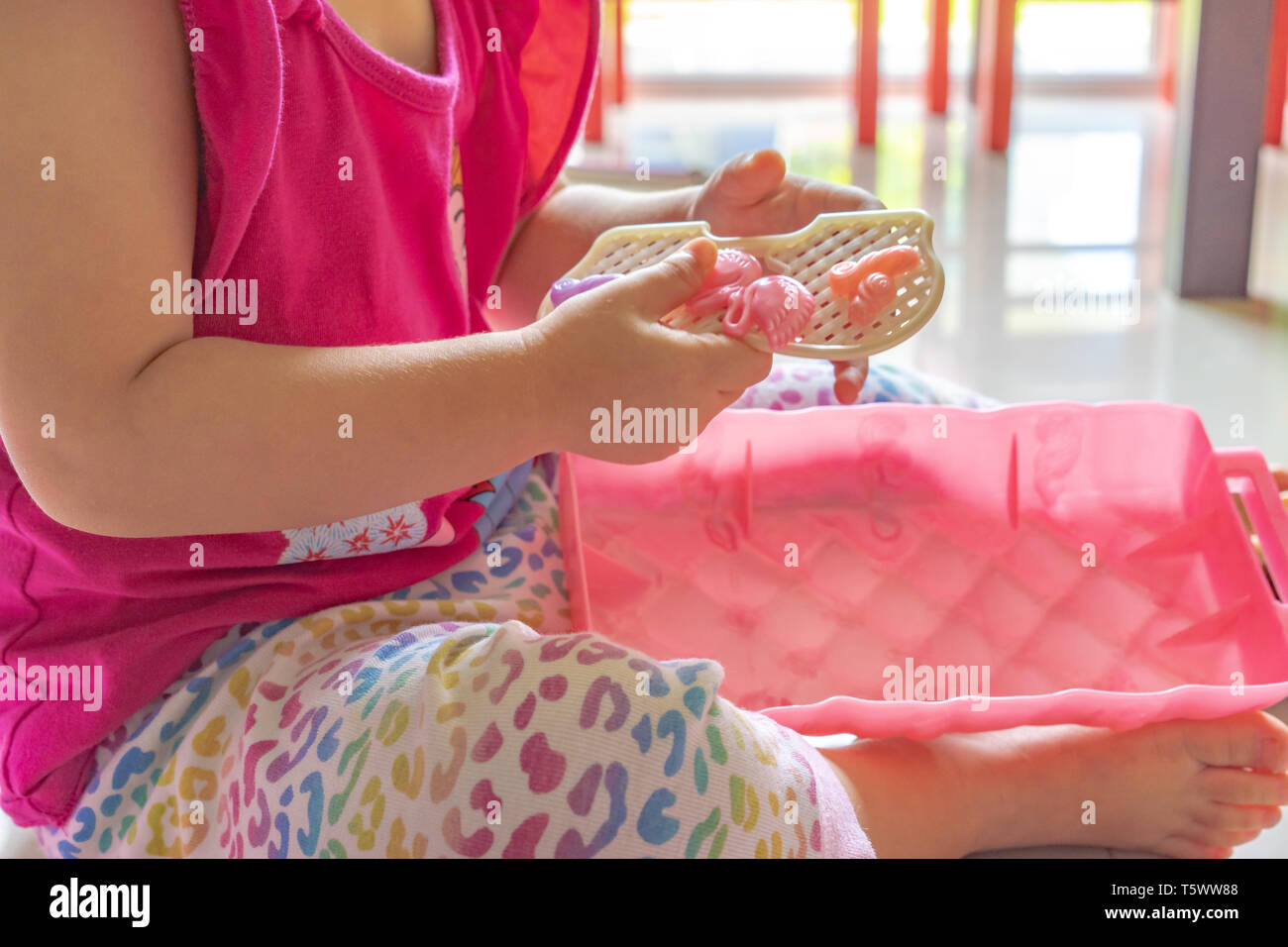 Girl in pink plays pink plastic toys Stock Photo - Alamy