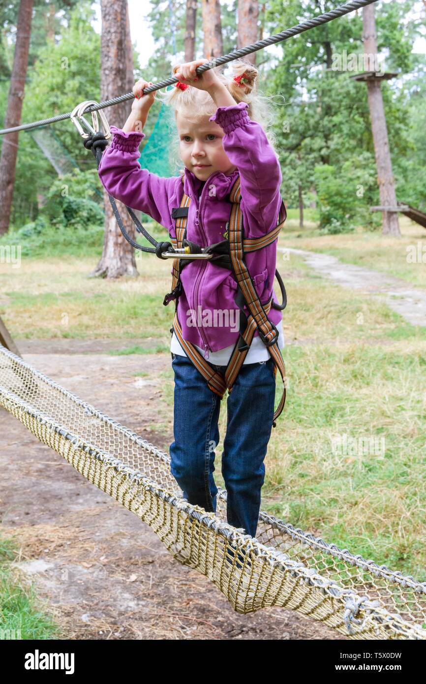 Girl child in adventure climbing high wire park, active lifestyle of ...