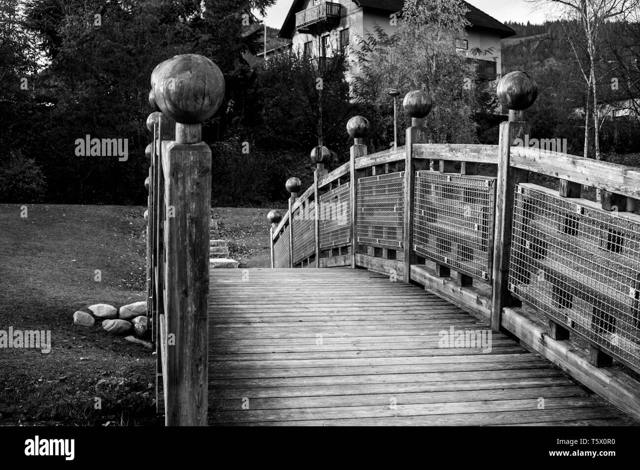 wooden detailed bridge in a lovely urban park in autumn with trees and ...