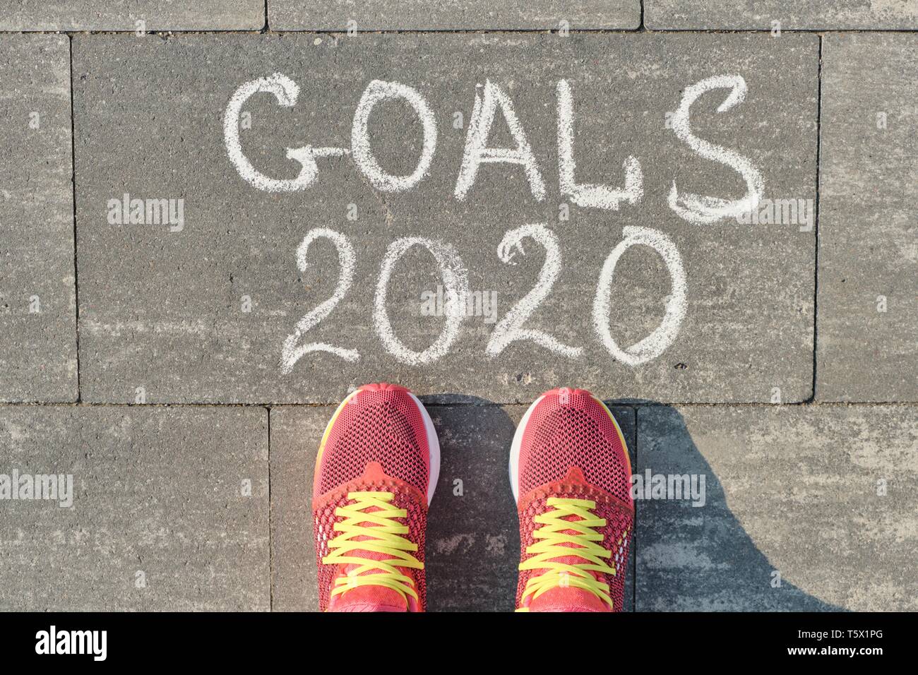 2020 goals, written on gray sidewalk with woman legs in sneakers, top ...
