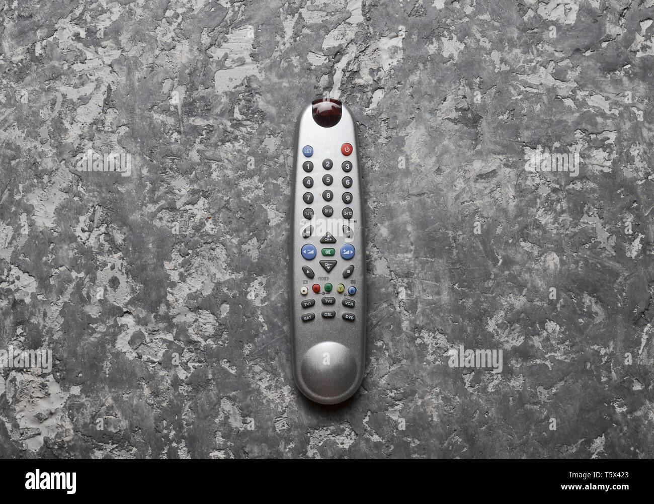 The TV controls on a gray concrete table. Top view. Remote control of ...