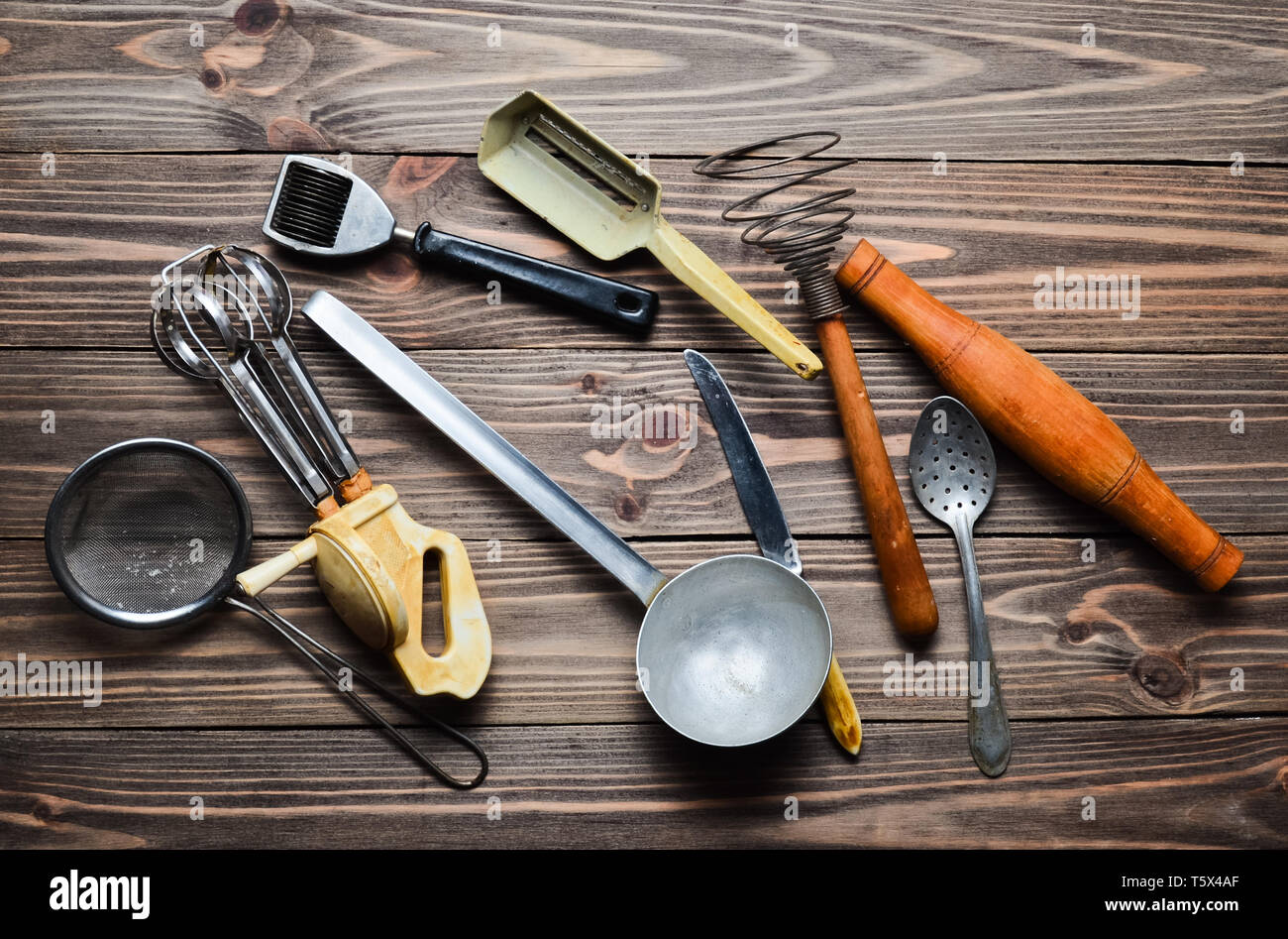 A set of old kitchen tools and cutlery on a wooden table. Vintage ...