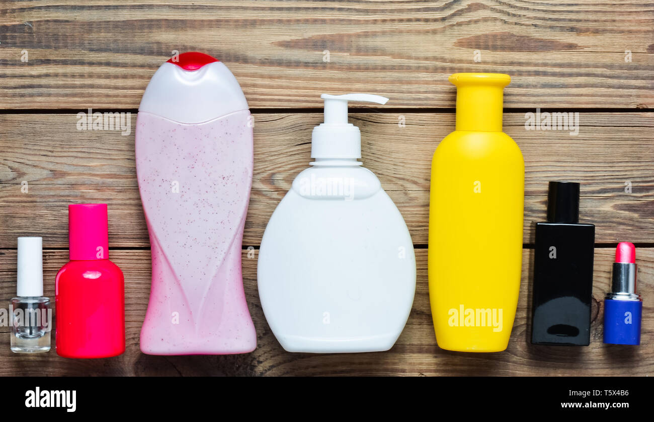 Products for showering in bottles and women's cosmetics on a wooden ...