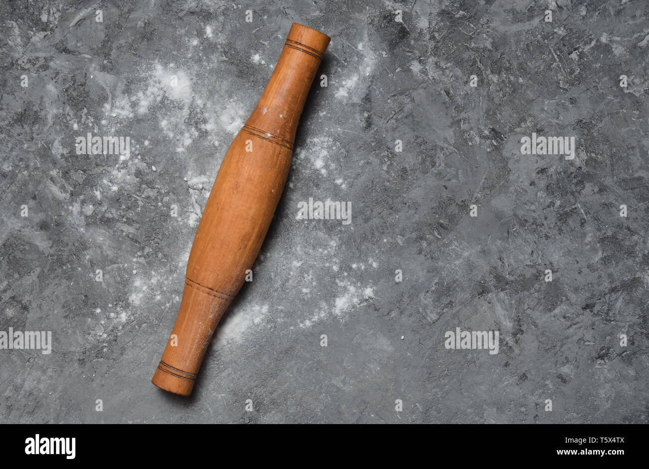 Rolling pin and flour on a concrete table. Kitchen tools. The cooking ...