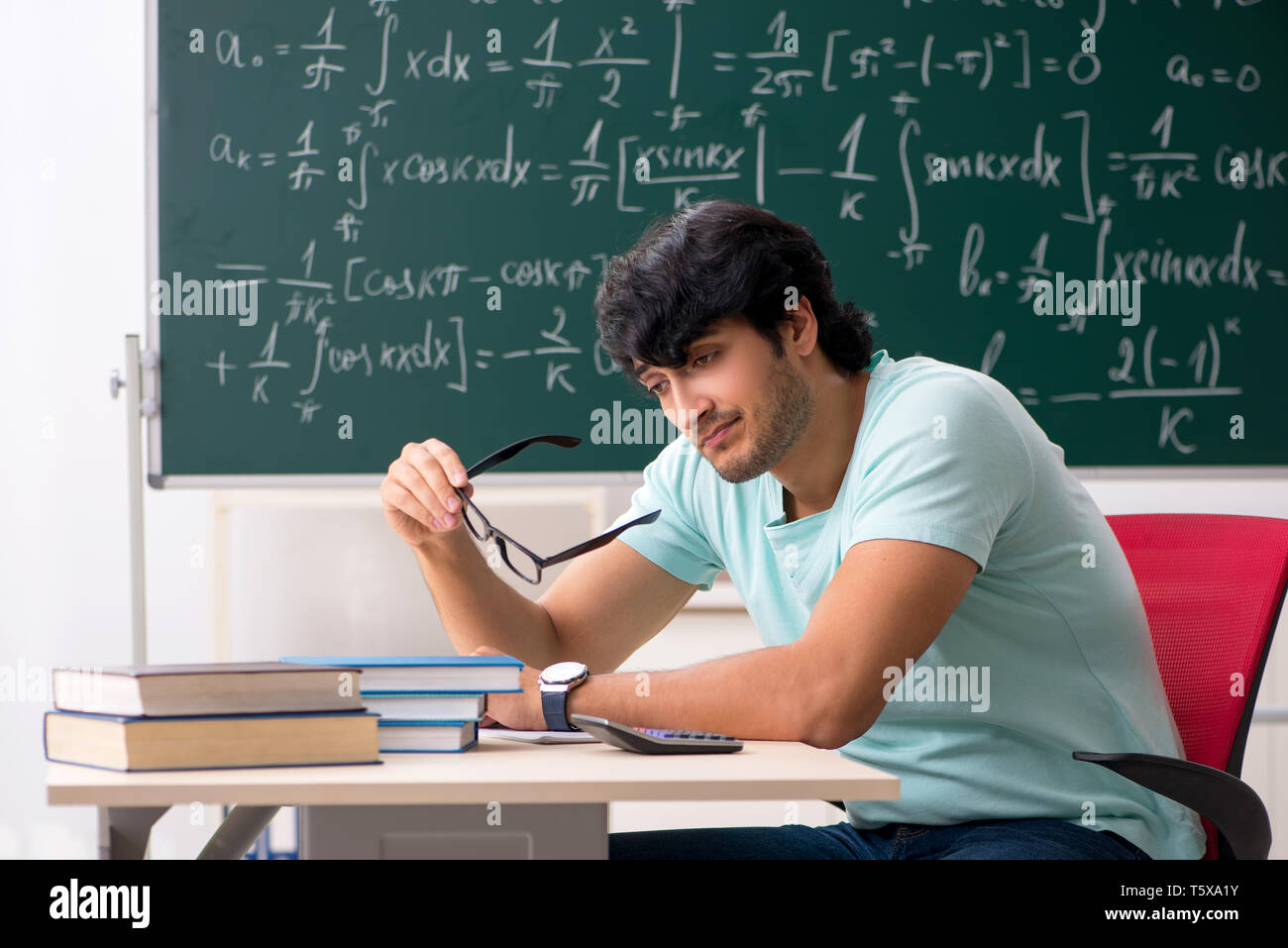 Young male student mathematician in front of chalkboard Stock Photo - Alamy