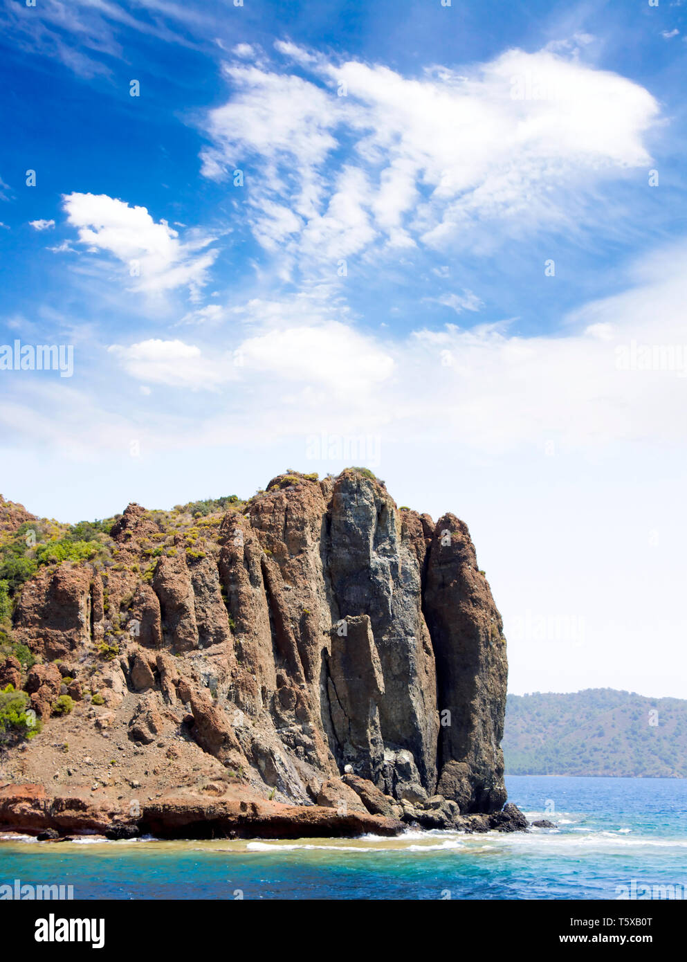 Rocky island in blue sea. Azure surf. Blue sky with white clouds Stock ...