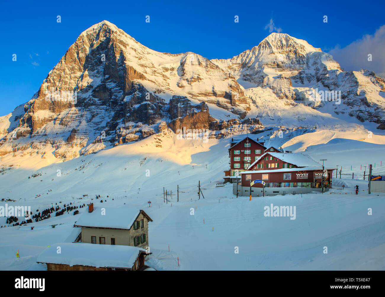 Chalets and hotel with north face of the Eiger and Monch mountains ...