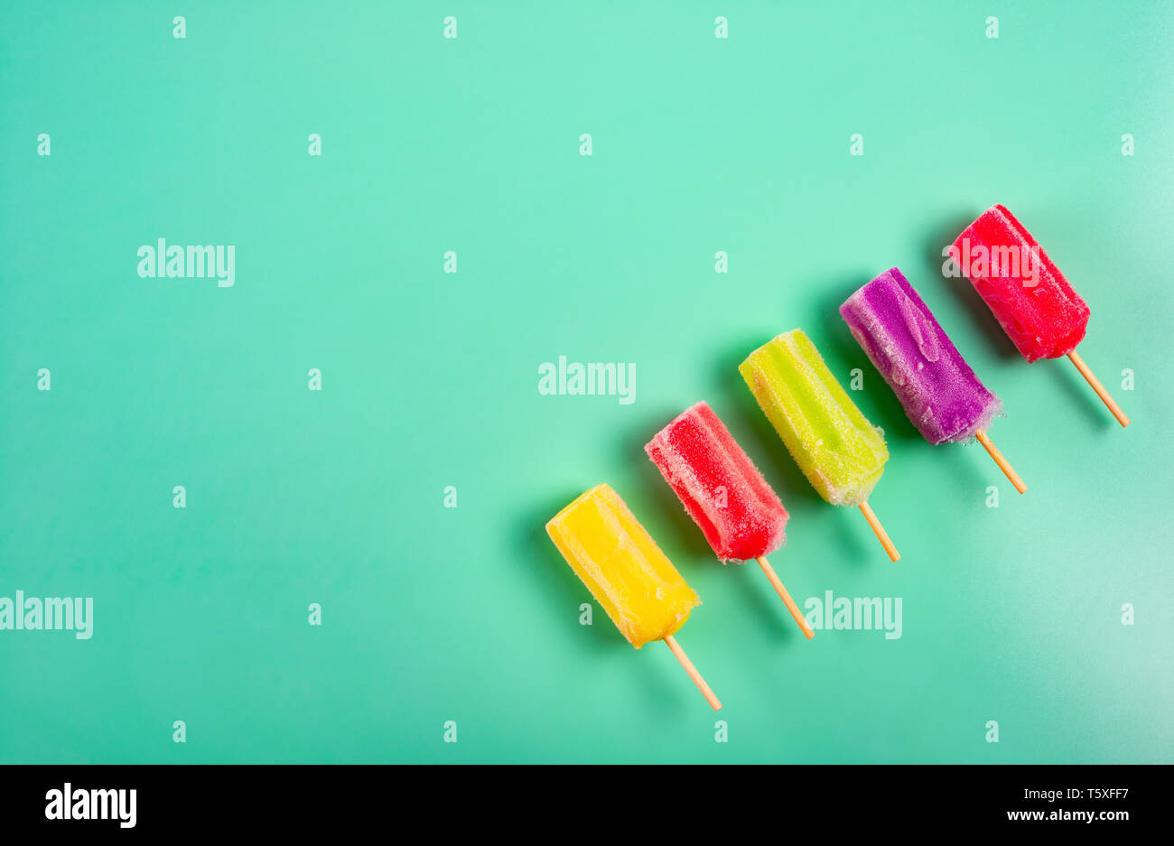 multi-color popsicles line up on green background with copy space Stock ...