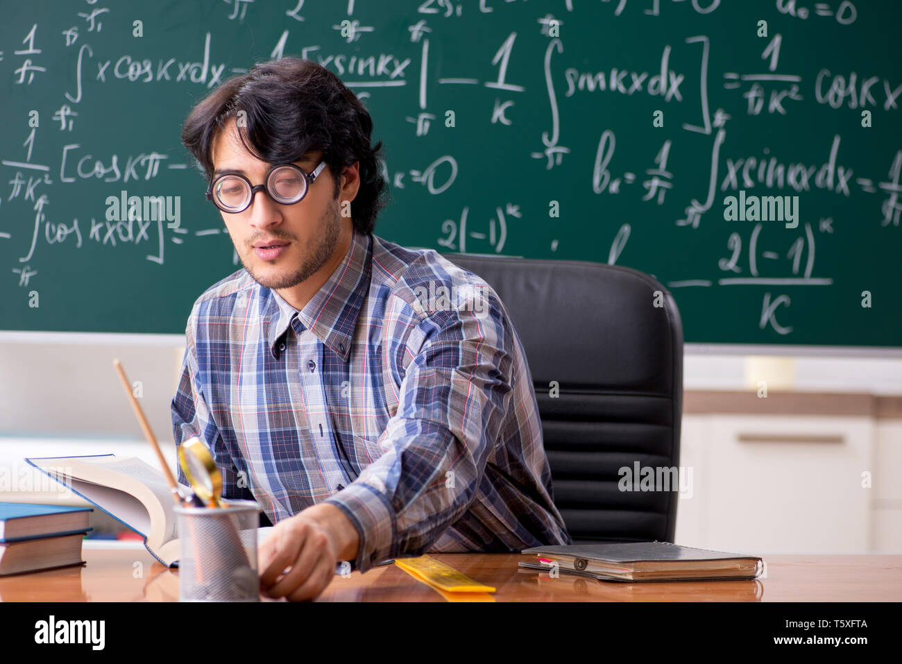 Funny male math teacher in the classroom Stock Photo - Alamy