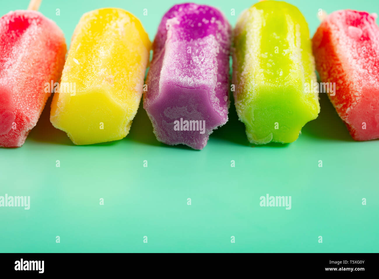 multi-color popsicles line up on green background with copy space Stock ...