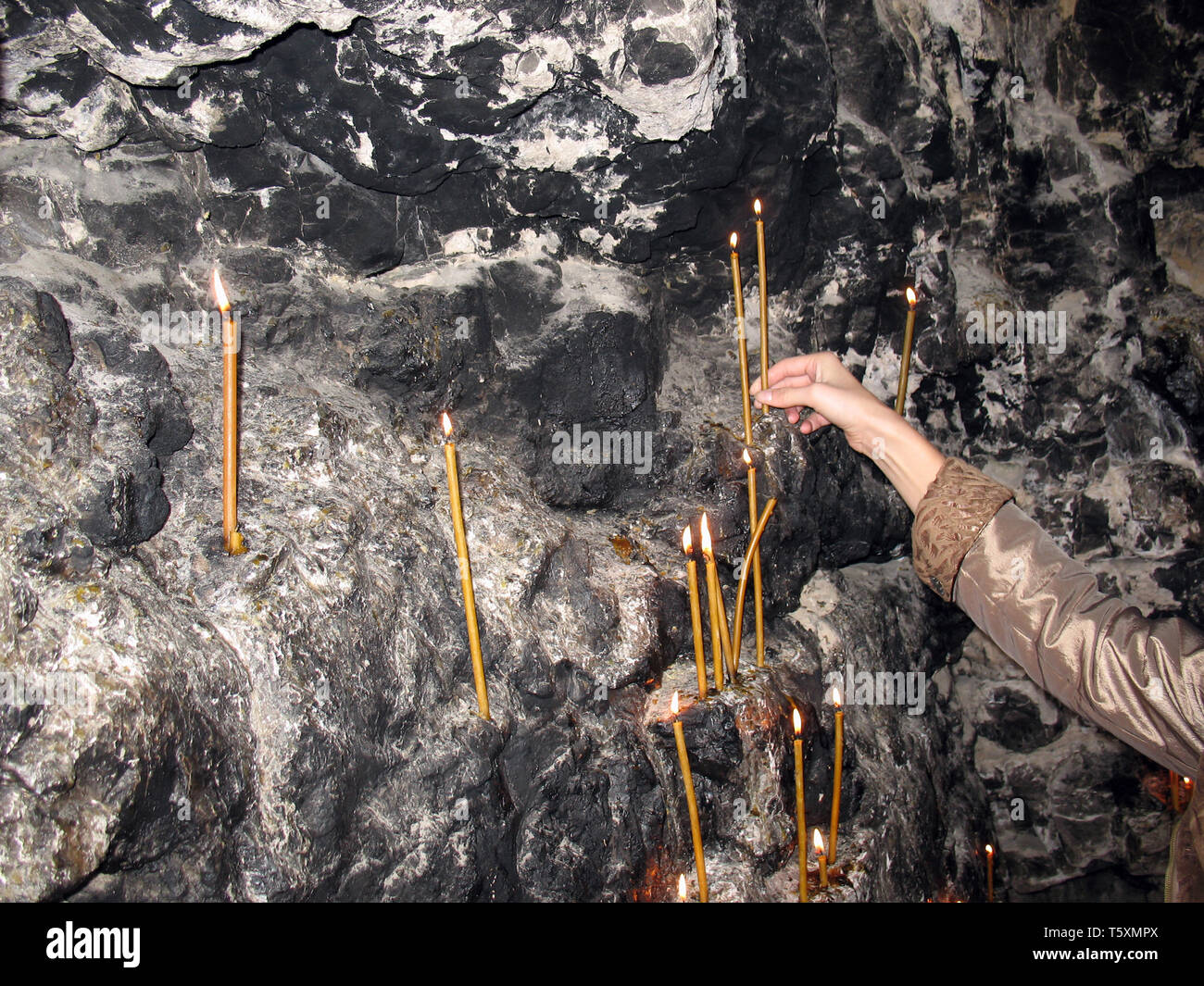 Christianity relic cave. Candles in grotto Stock Photo - Alamy