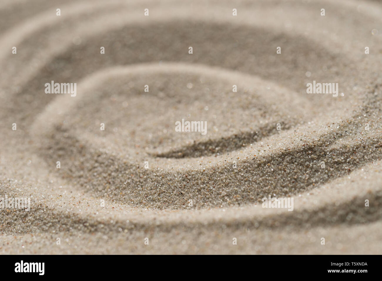 concentric circles pattern on natural sand texture background closeup ...