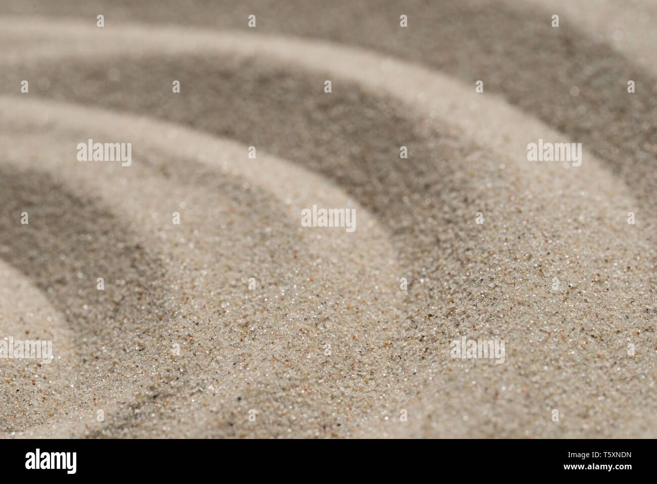 concentric circles pattern on natural sand texture background closeup ...