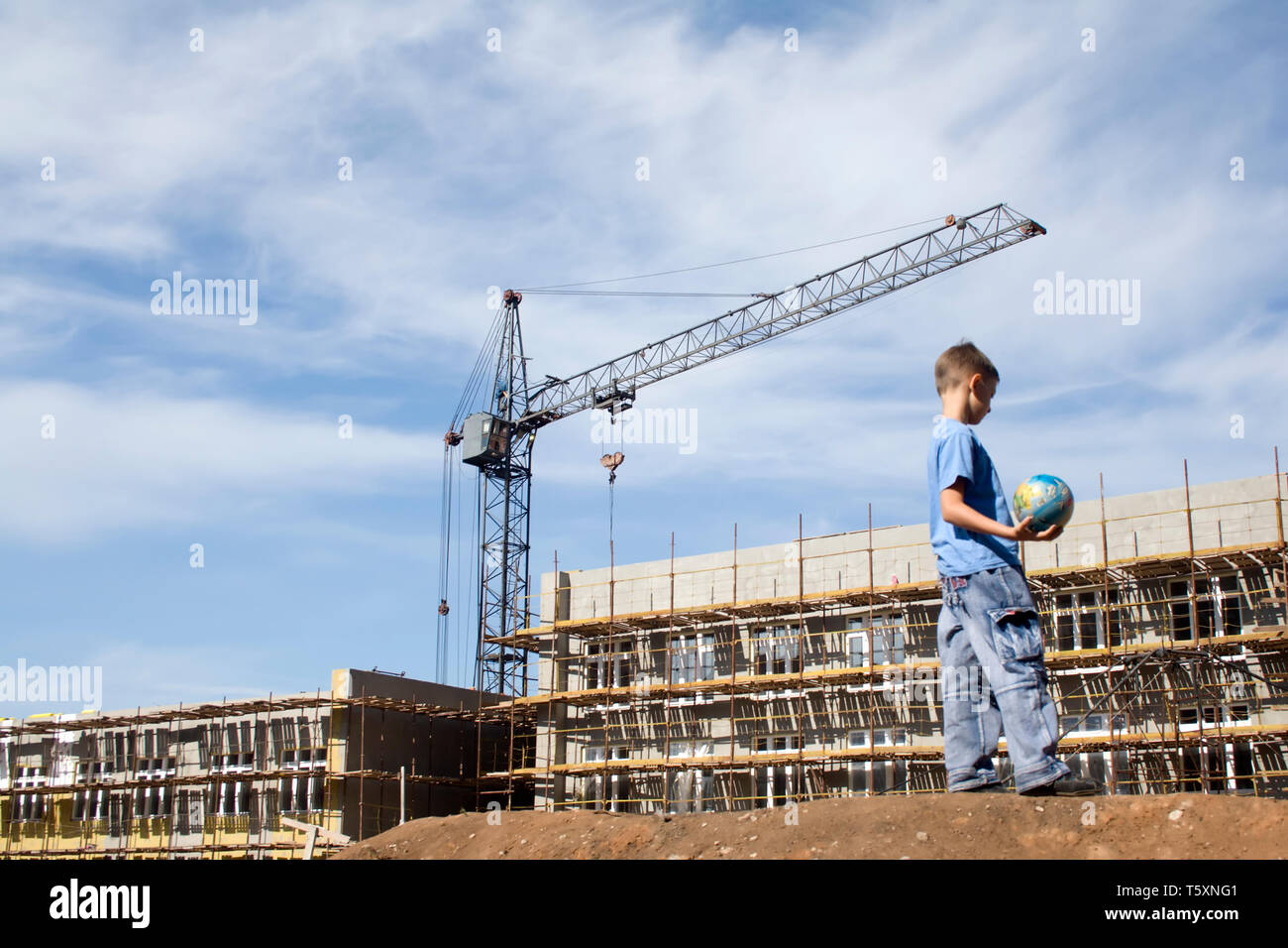 Young boy play on building area with ball Stock Photo - Alamy