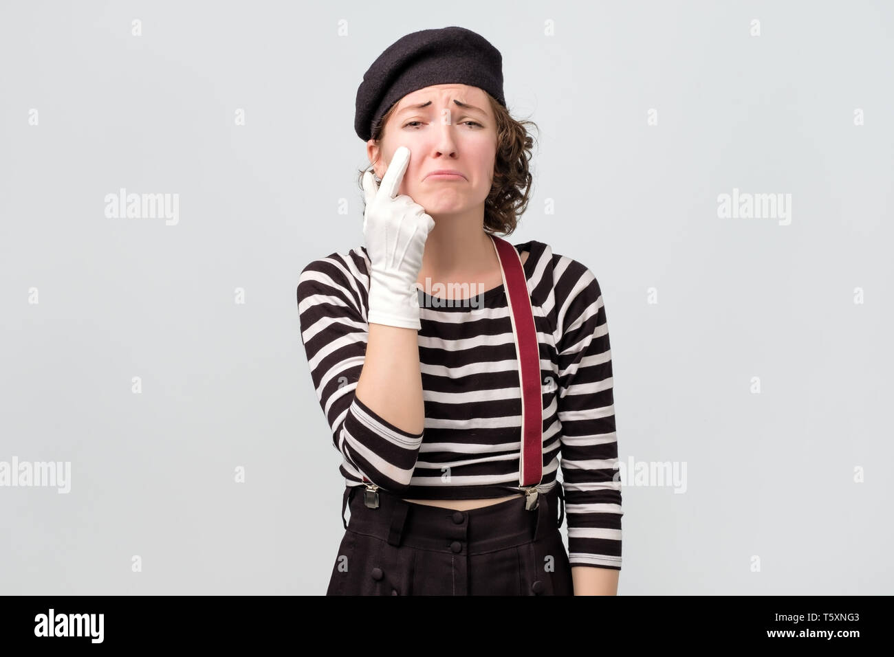 Sad crying girl dressed like mime wiping tears from eyes with fingers ...