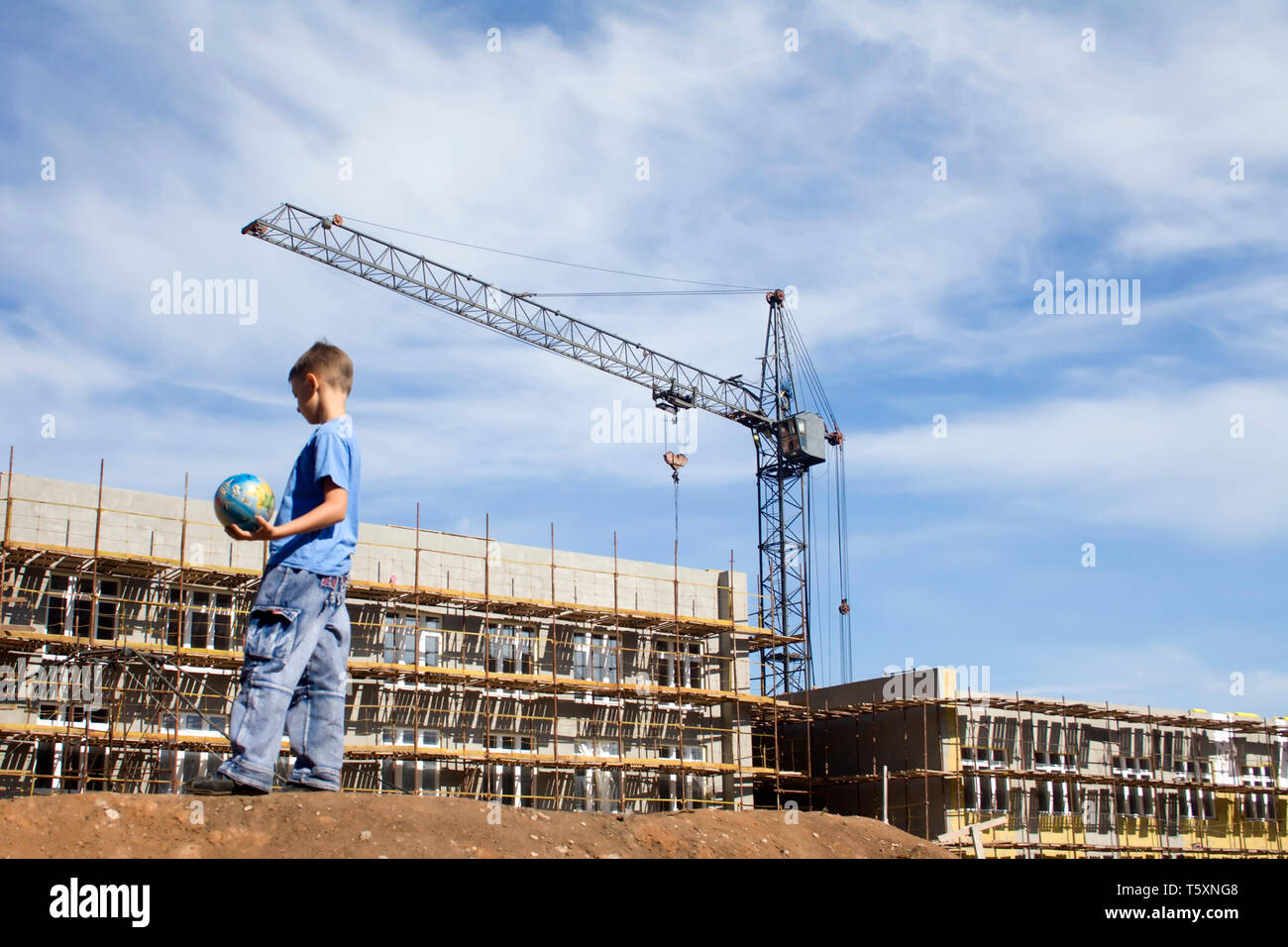 Young boy play on building area with ball Stock Photo - Alamy