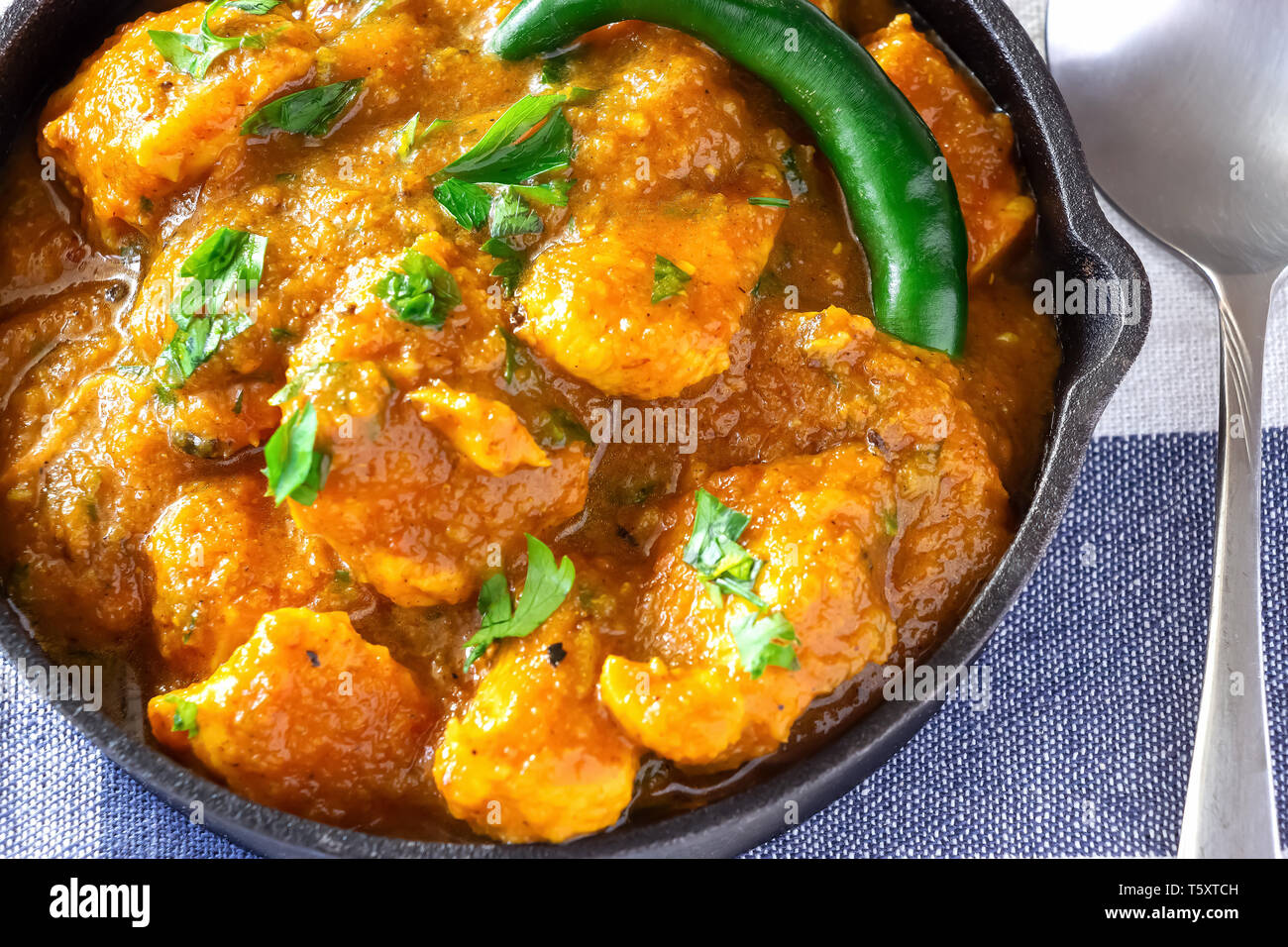 Close up traditional Indian butter chicken curry and lemon served with ...